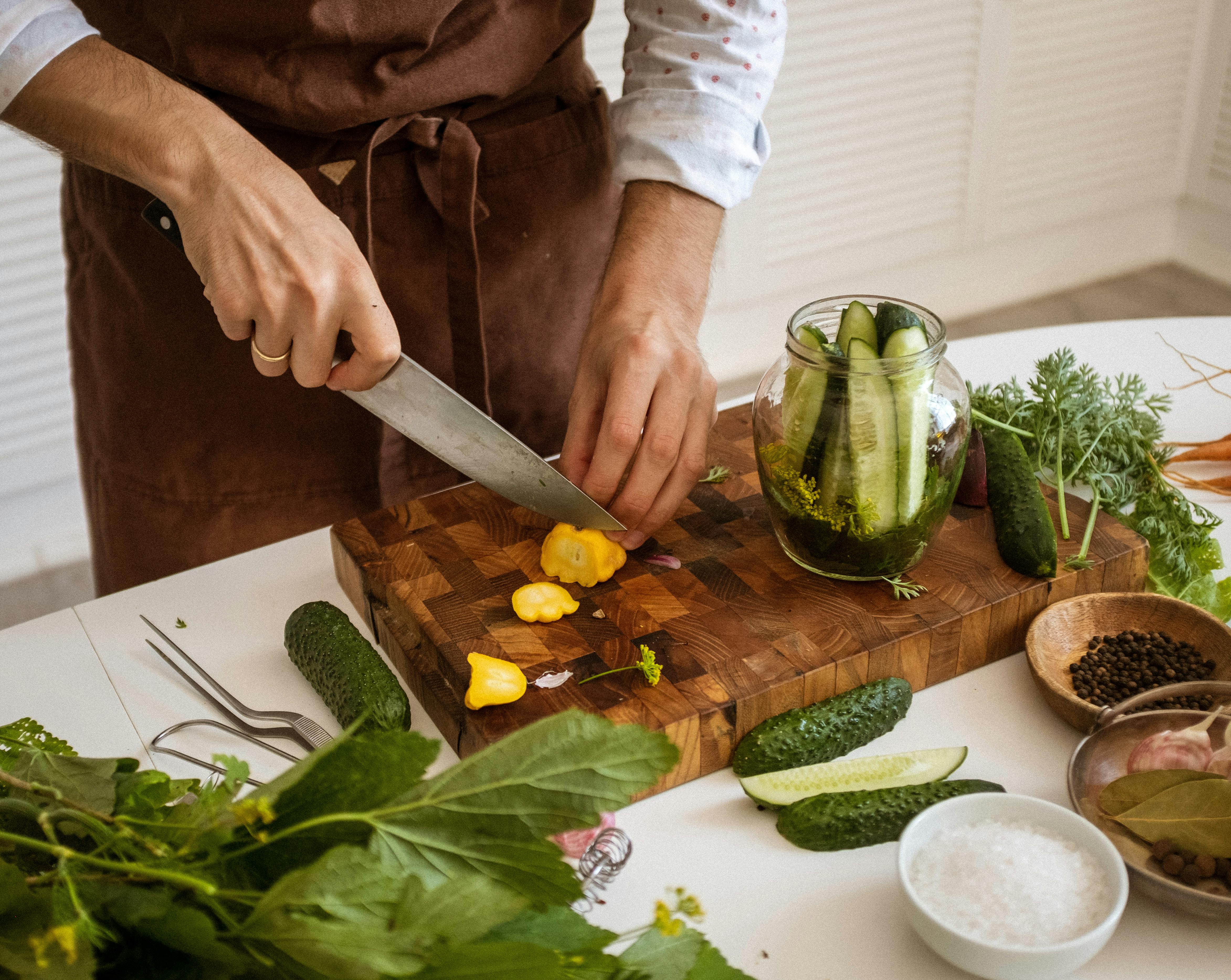 Person Slicing Vegetable on Chopping Board · Free Stock Photo