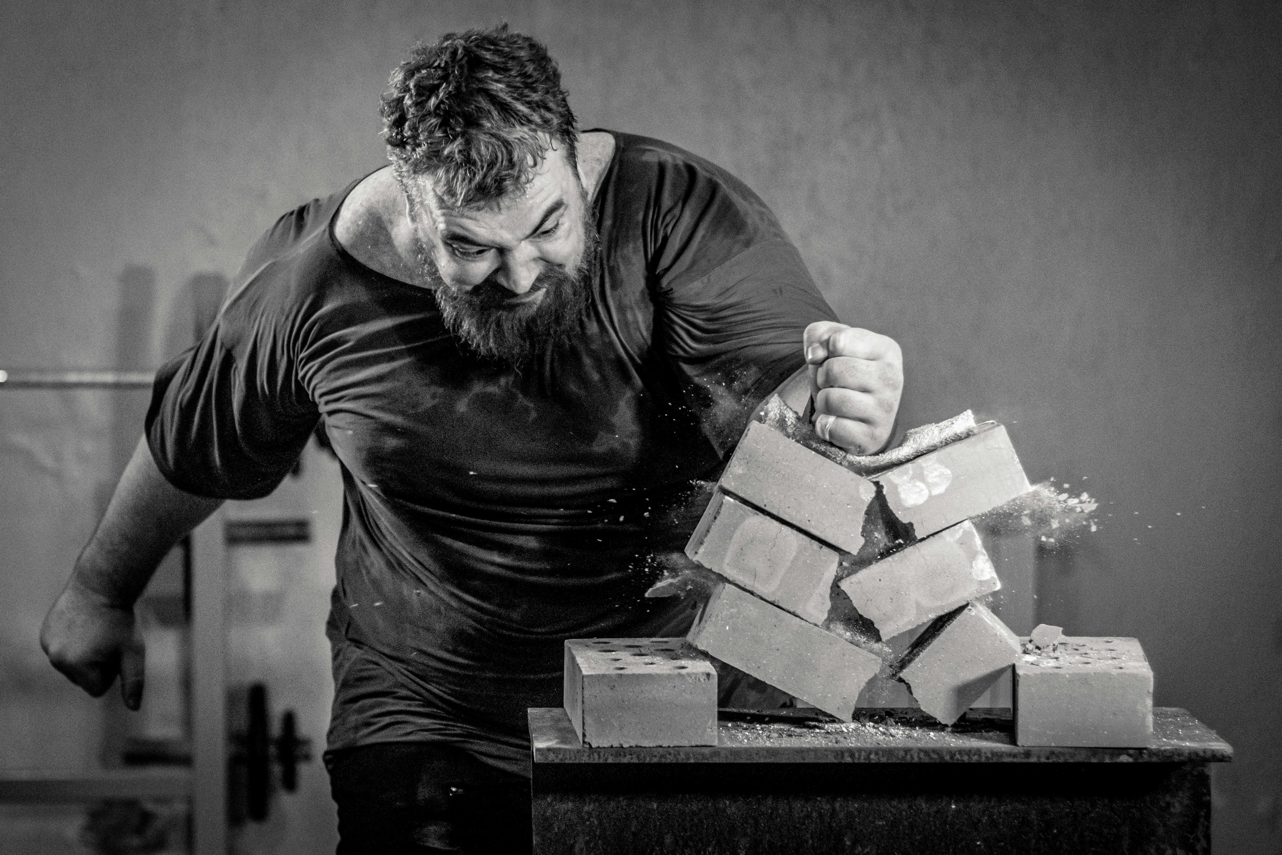 A Man Breaking Concrete Block Using His Hand · Free Stock Photo