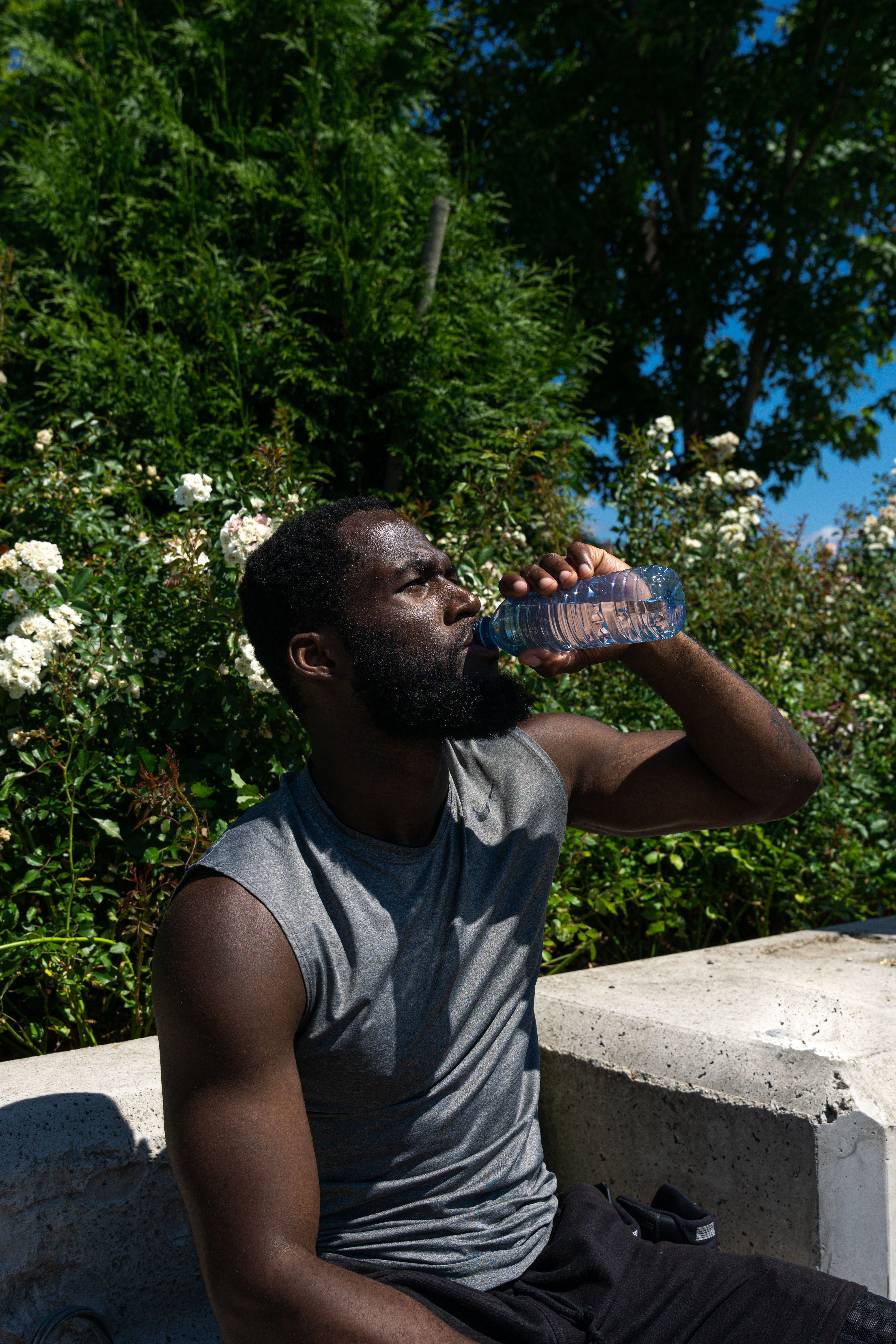 Man in Gray Tank Top Drinking Water · Free Stock Photo