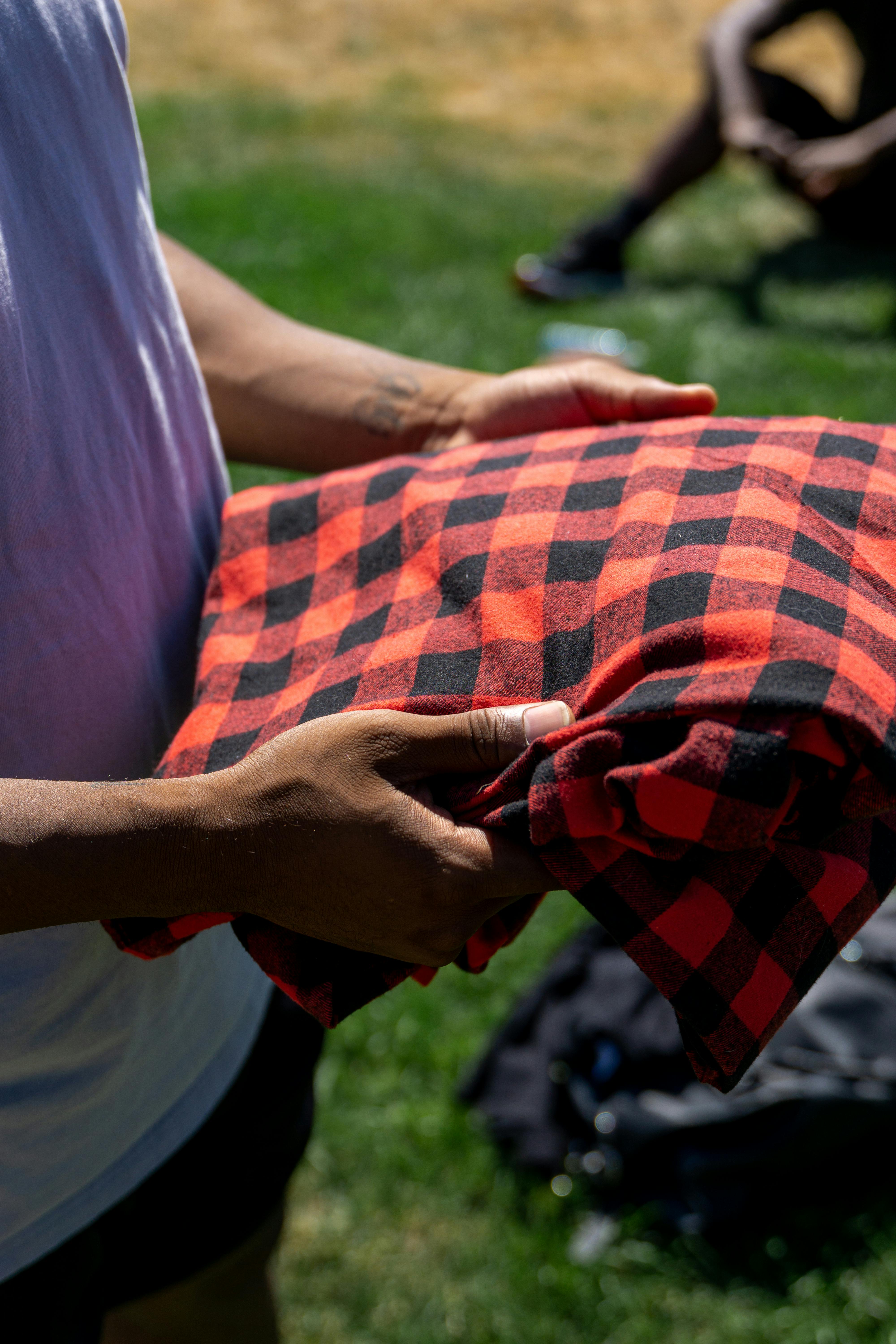 Close-Up Photo of a Person Holding a Plaid Blanket · Free Stock Photo