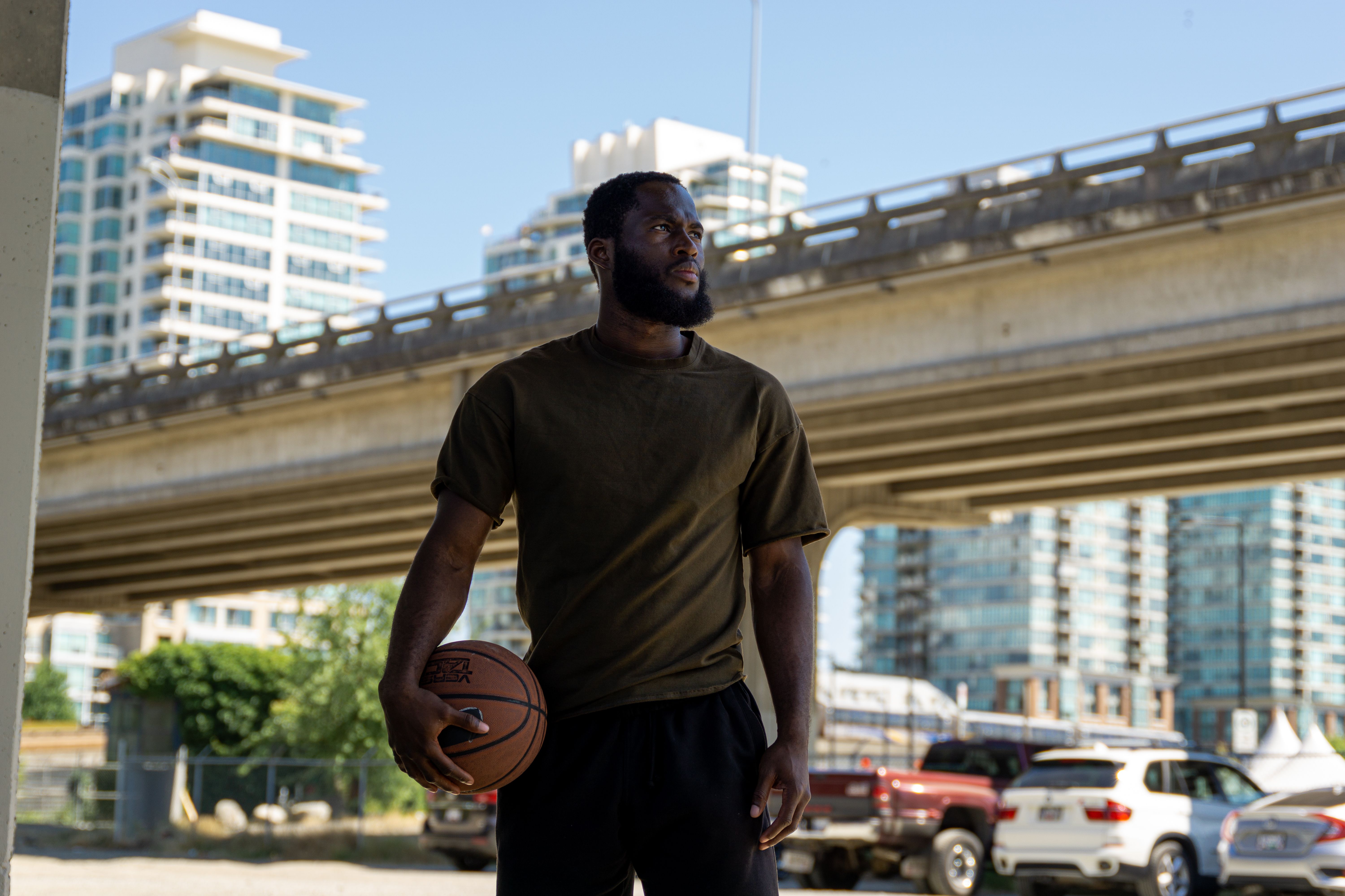 A Man Looking Up While Holding a Basketball · Free Stock Photo
