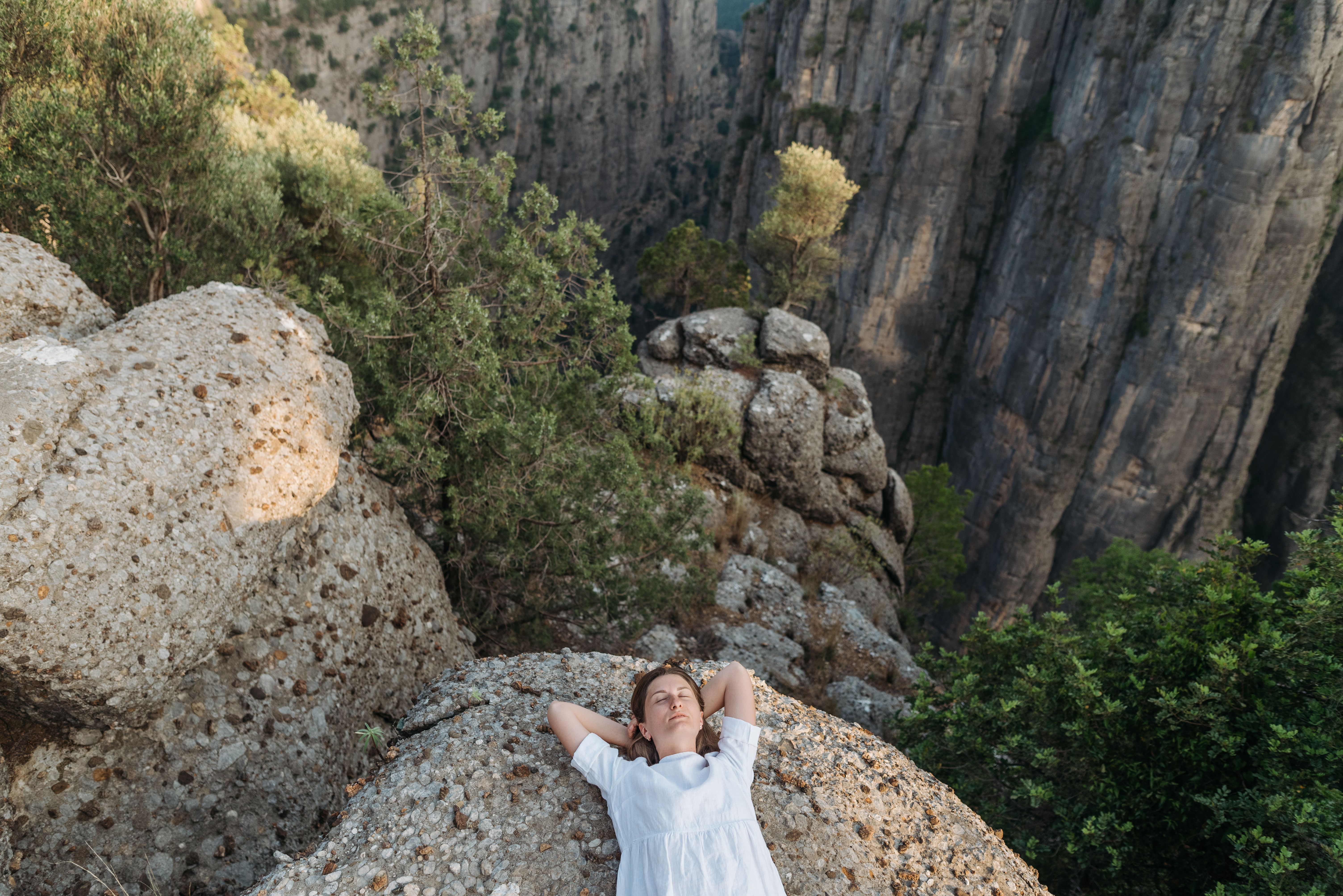 Woman Lying on a Rock Cliff · Free Stock Photo
