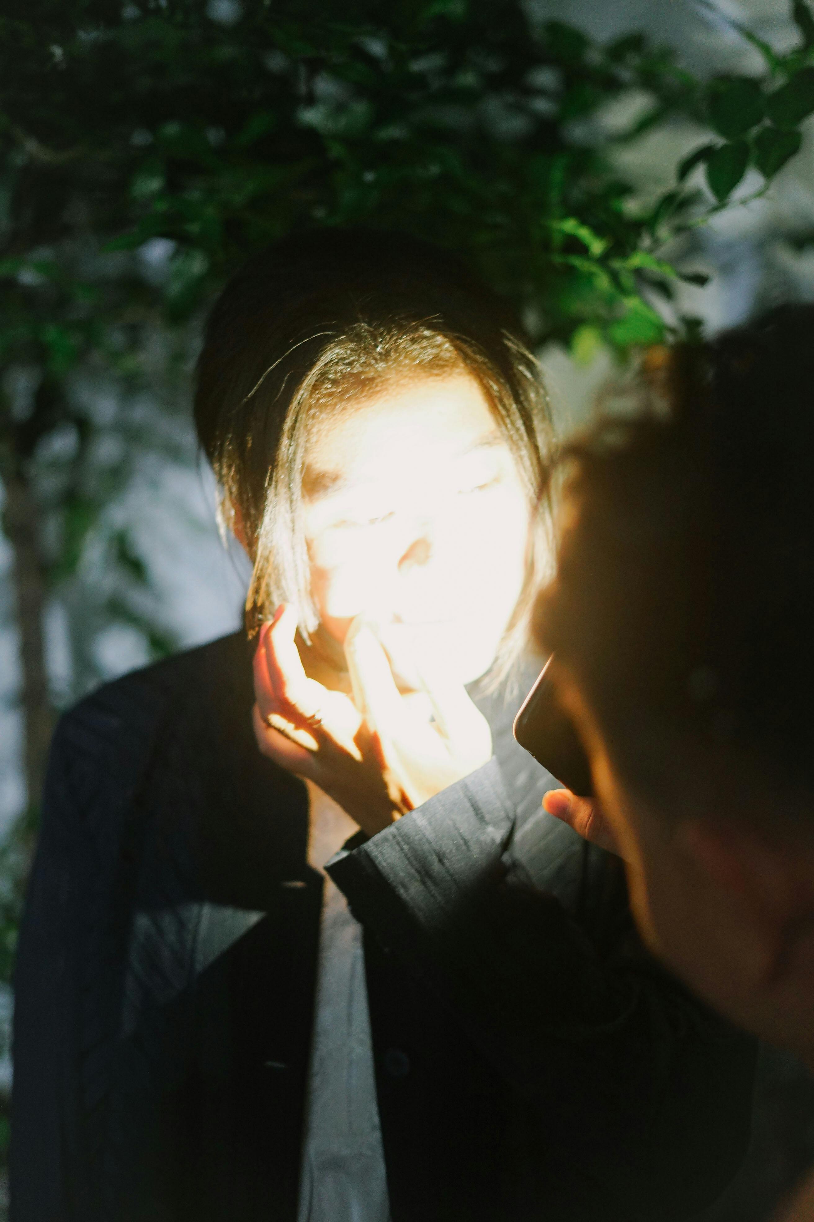 Man Holding a Flashlight Close to a Womans Face · Free Stock Photo