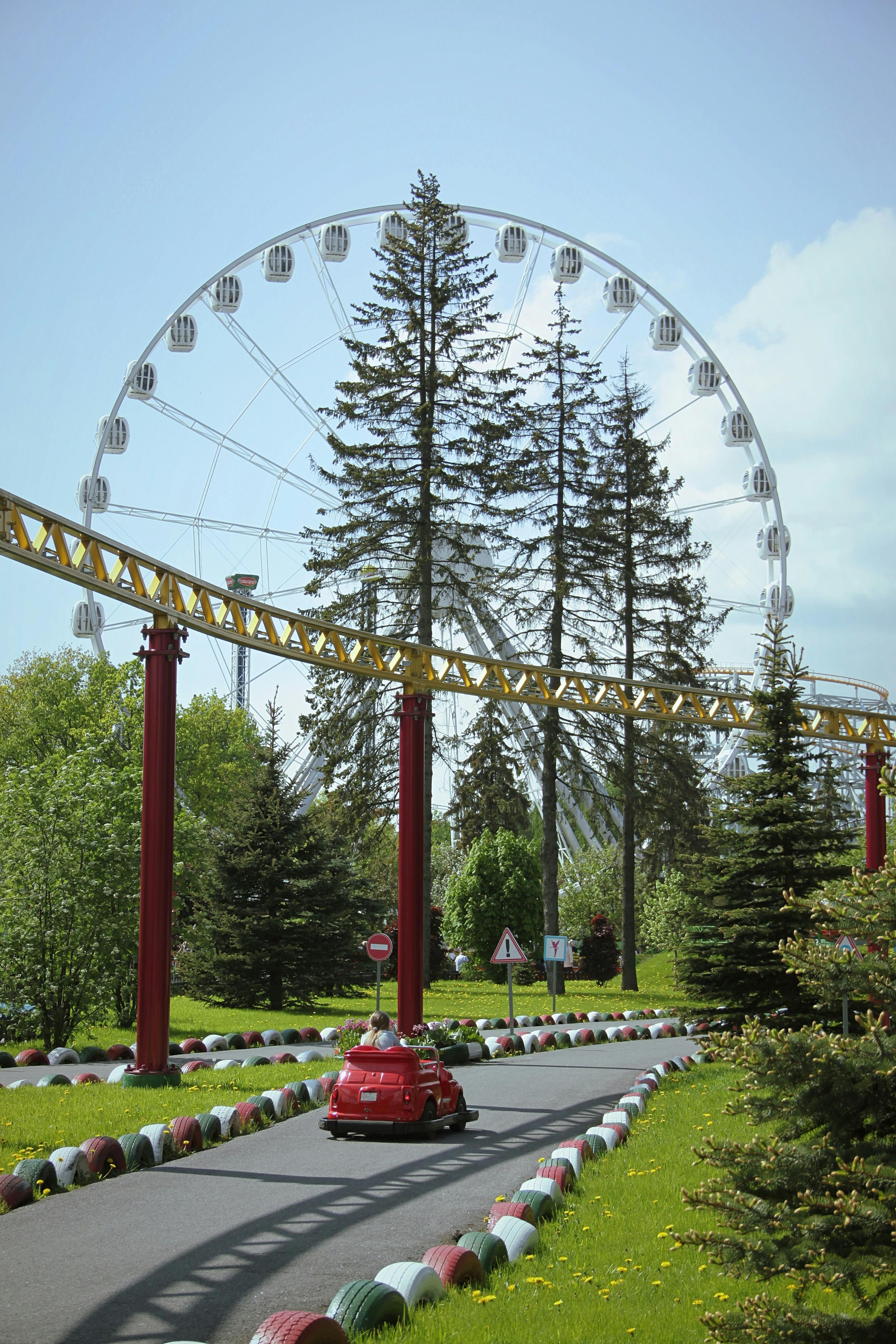 Theme Park Car Ride and a Ferris Wheel in the Background · Free Stock Photo