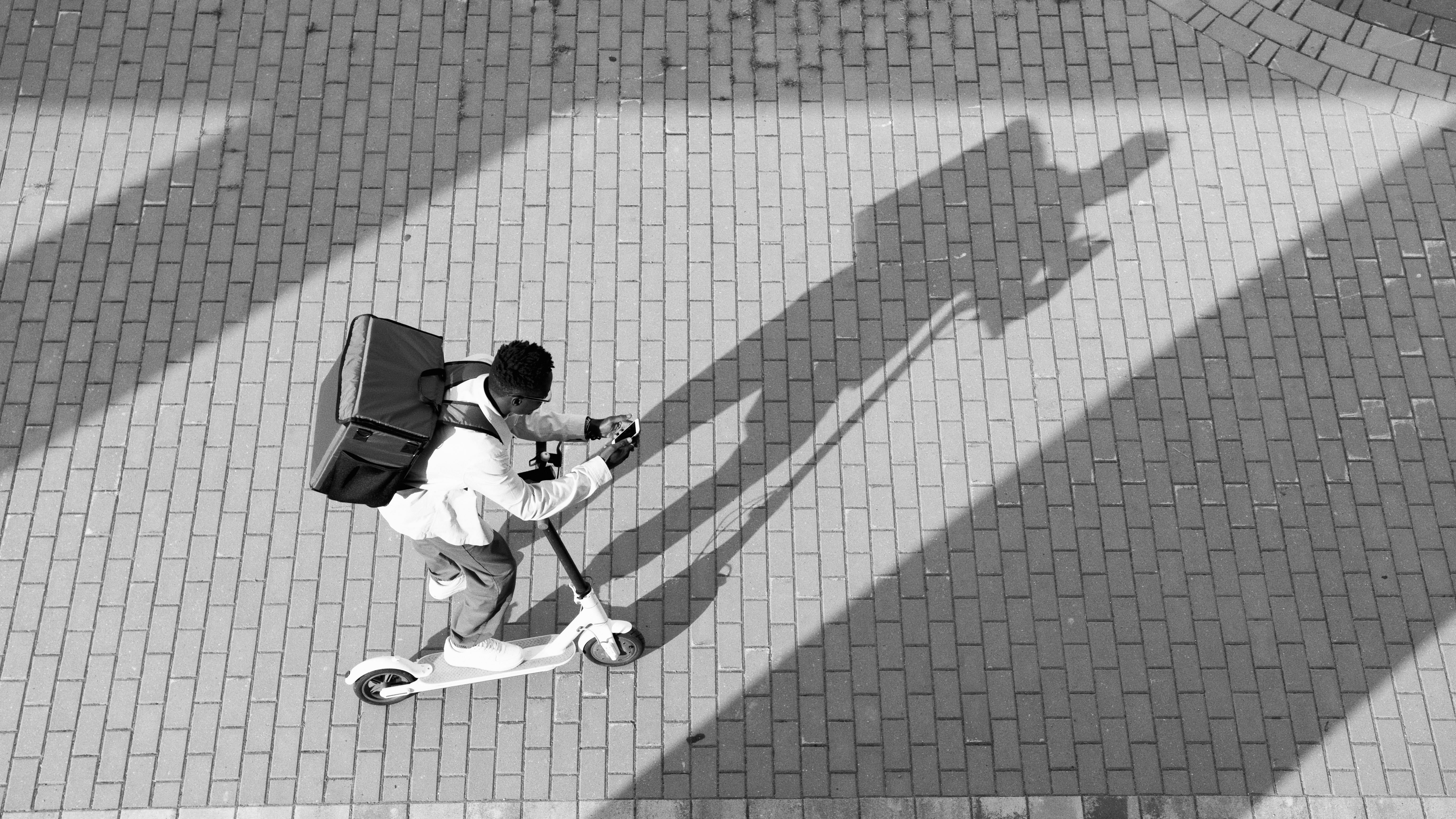 Man With Backpack Riding a Scooter · Free Stock Photo