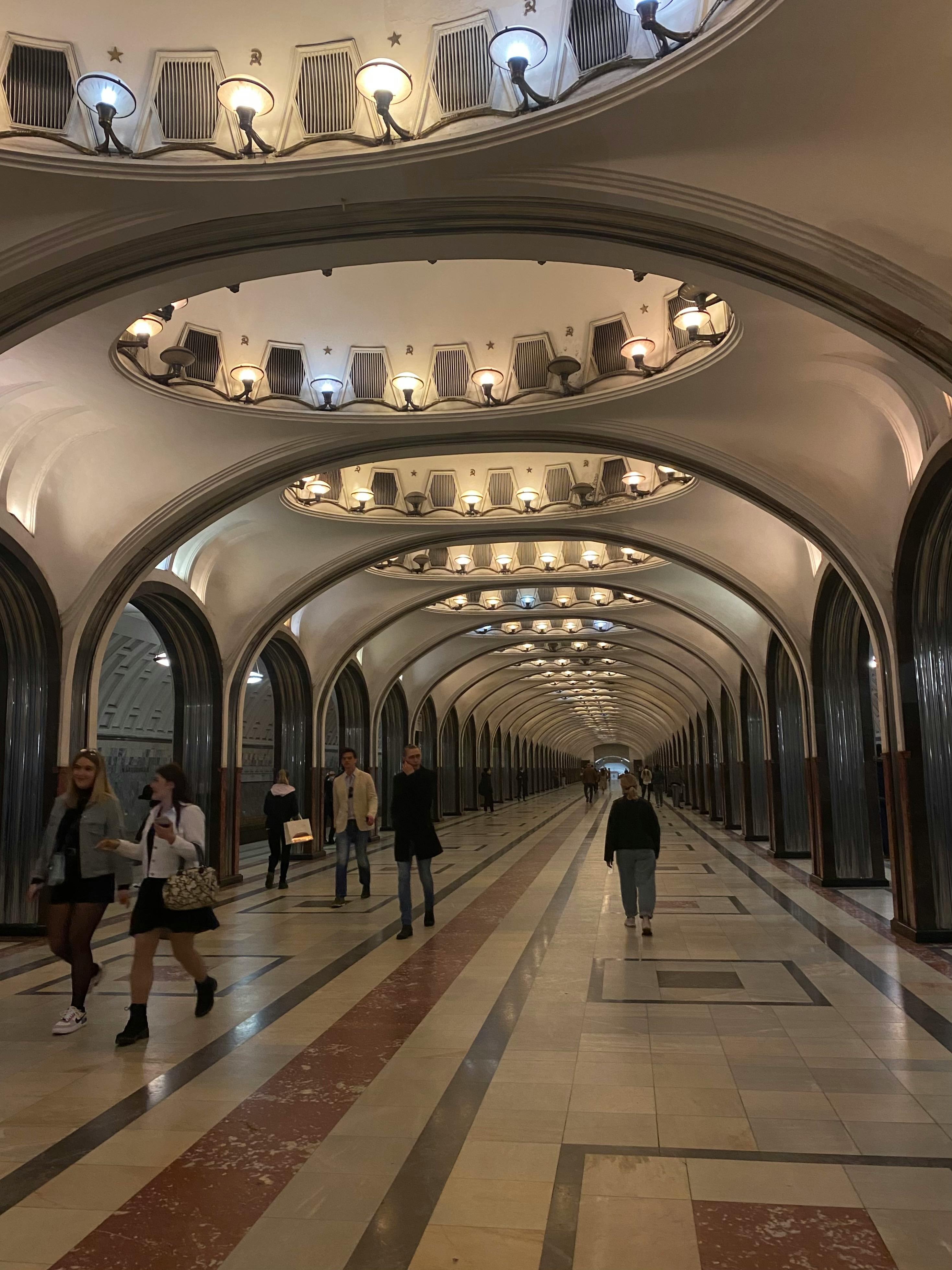 People Walking on a Hallway with Pillars · Free Stock Photo