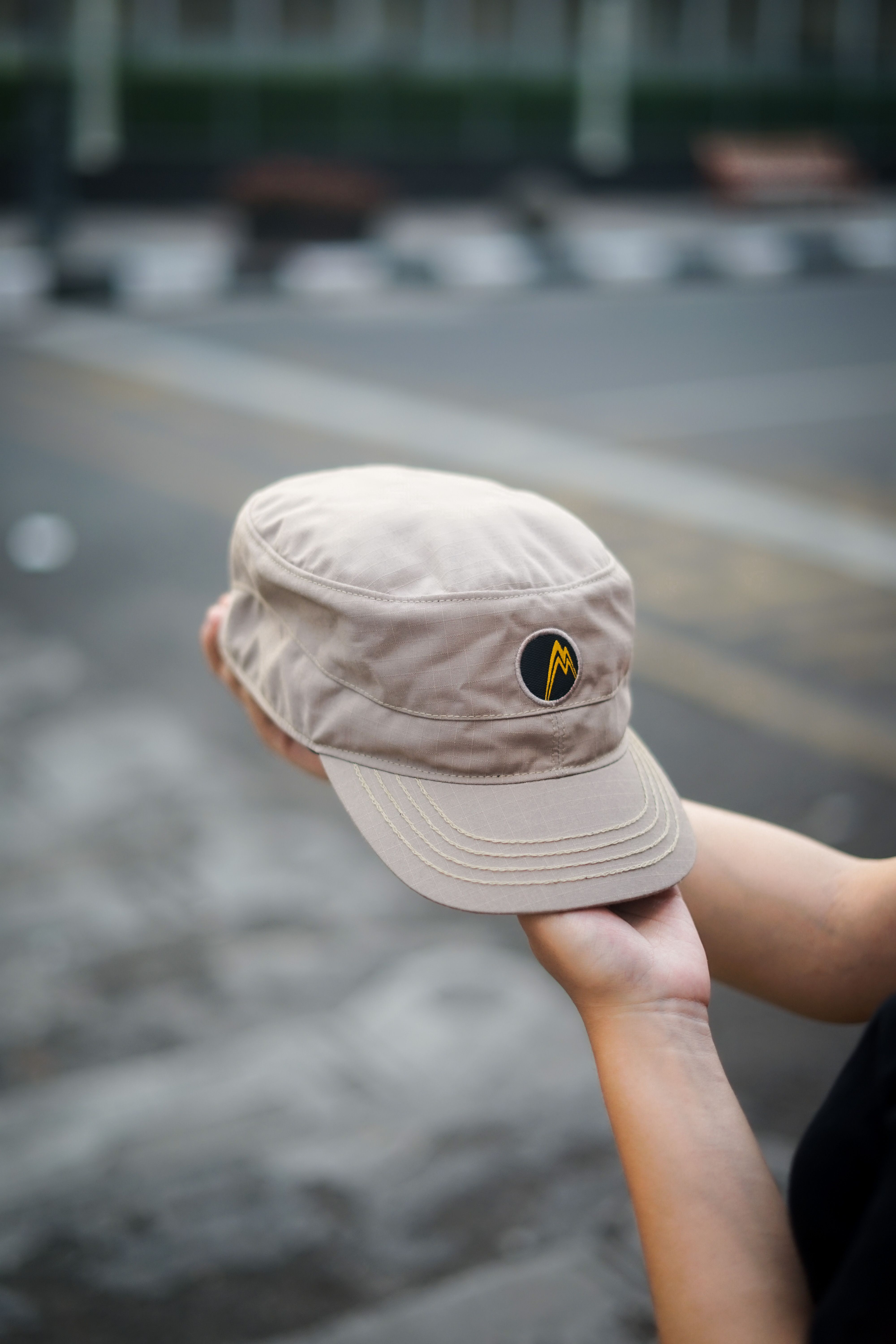 A Person Holding a Beige Cap · Free Stock Photo