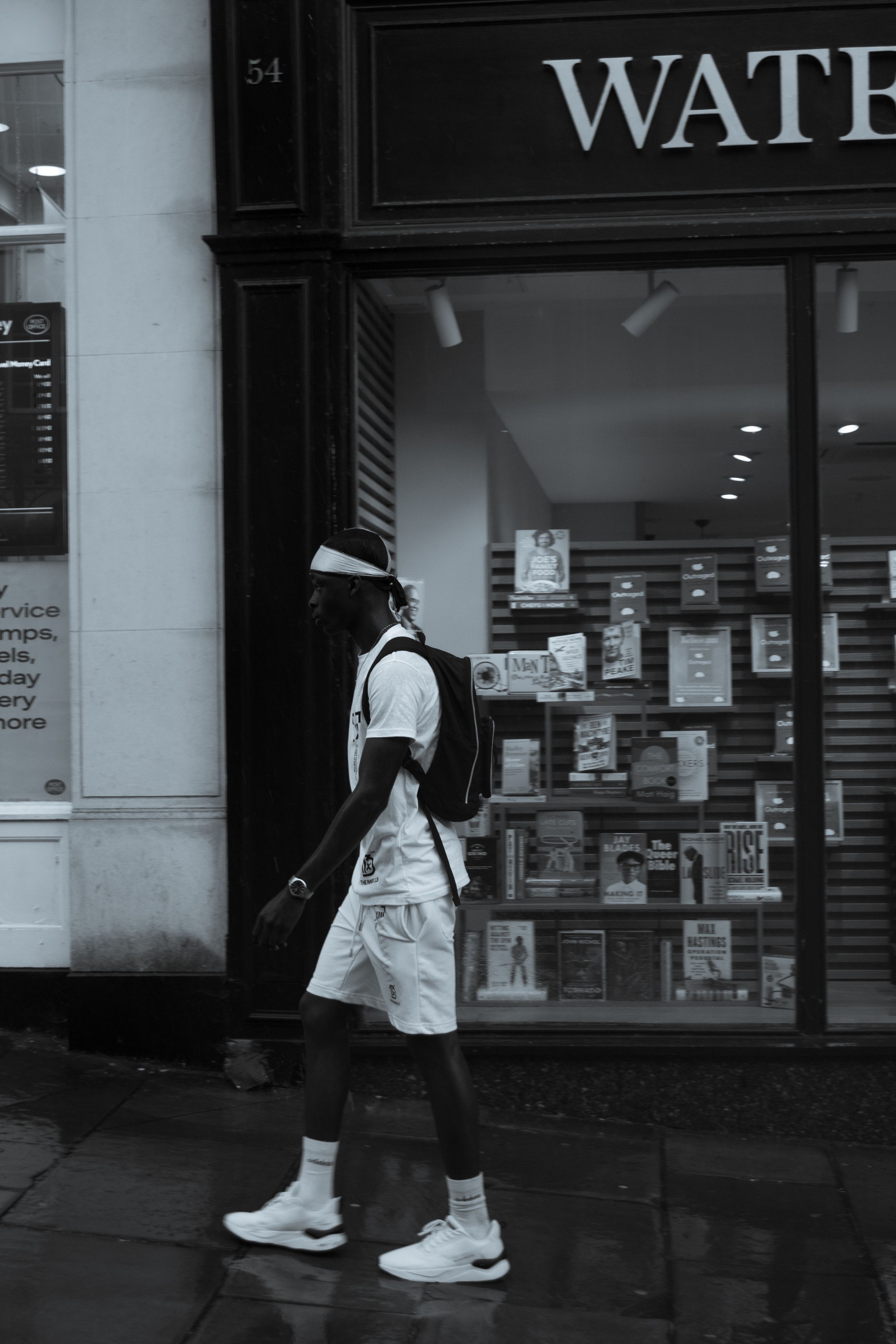 Man Walking on a Sidewalk Dragging a Bag on Wheels · Free Stock Photo