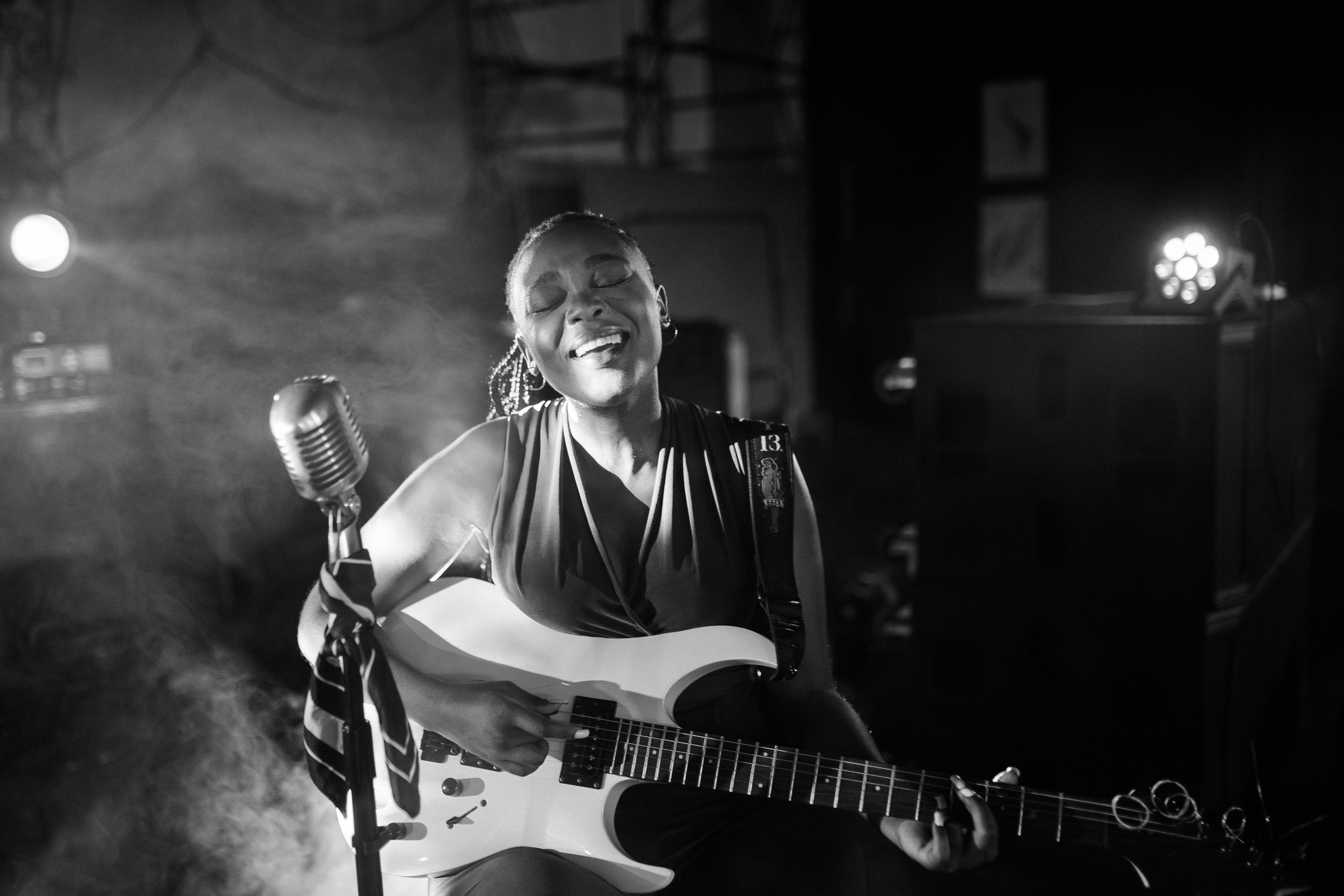 A Woman Singing While Playing the Guitar · Free Stock Photo