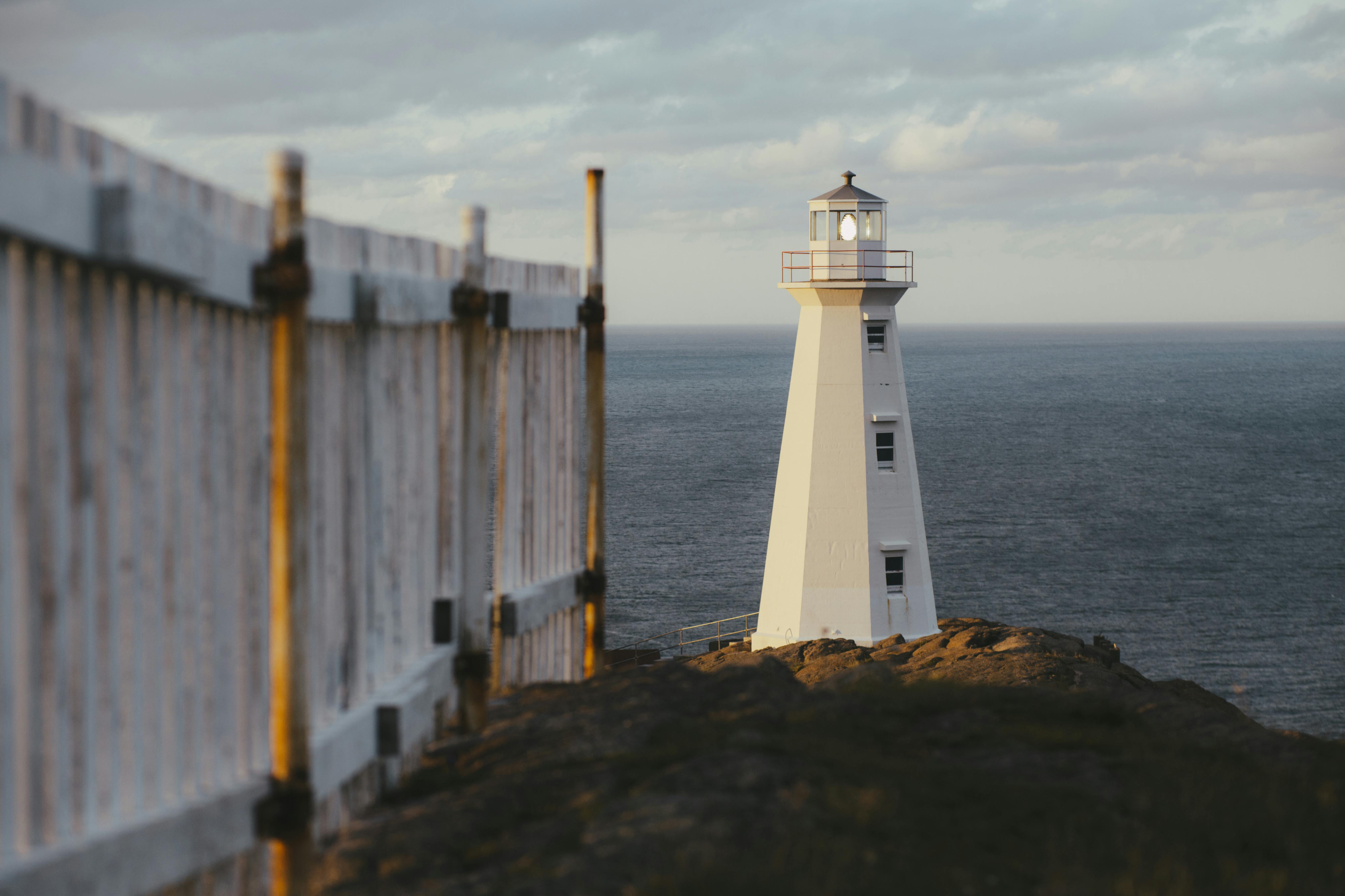 White Lighthouse Near Body of Water · Free Stock Photo