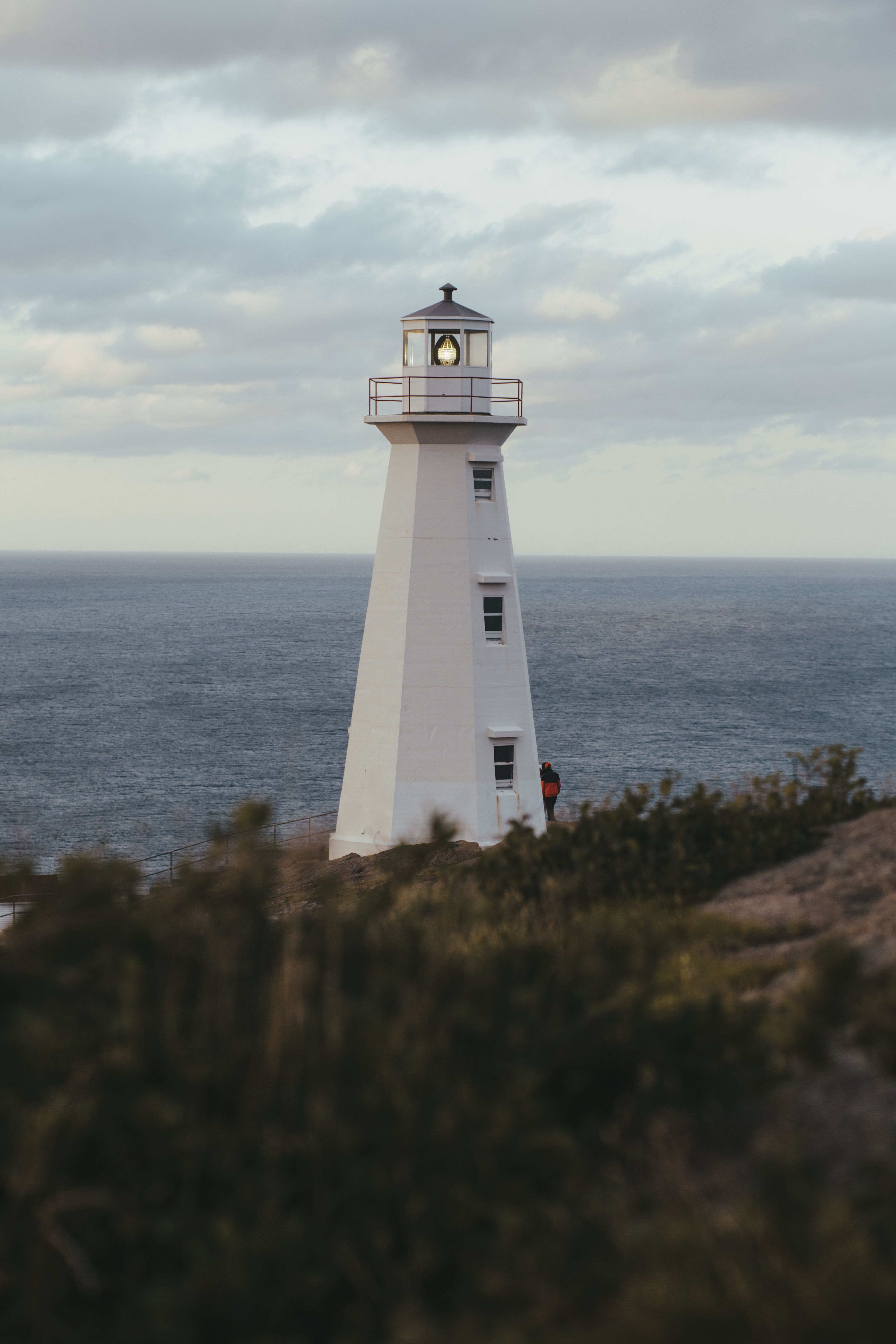 A White Lighthouse Near a Body of Water · Free Stock Photo