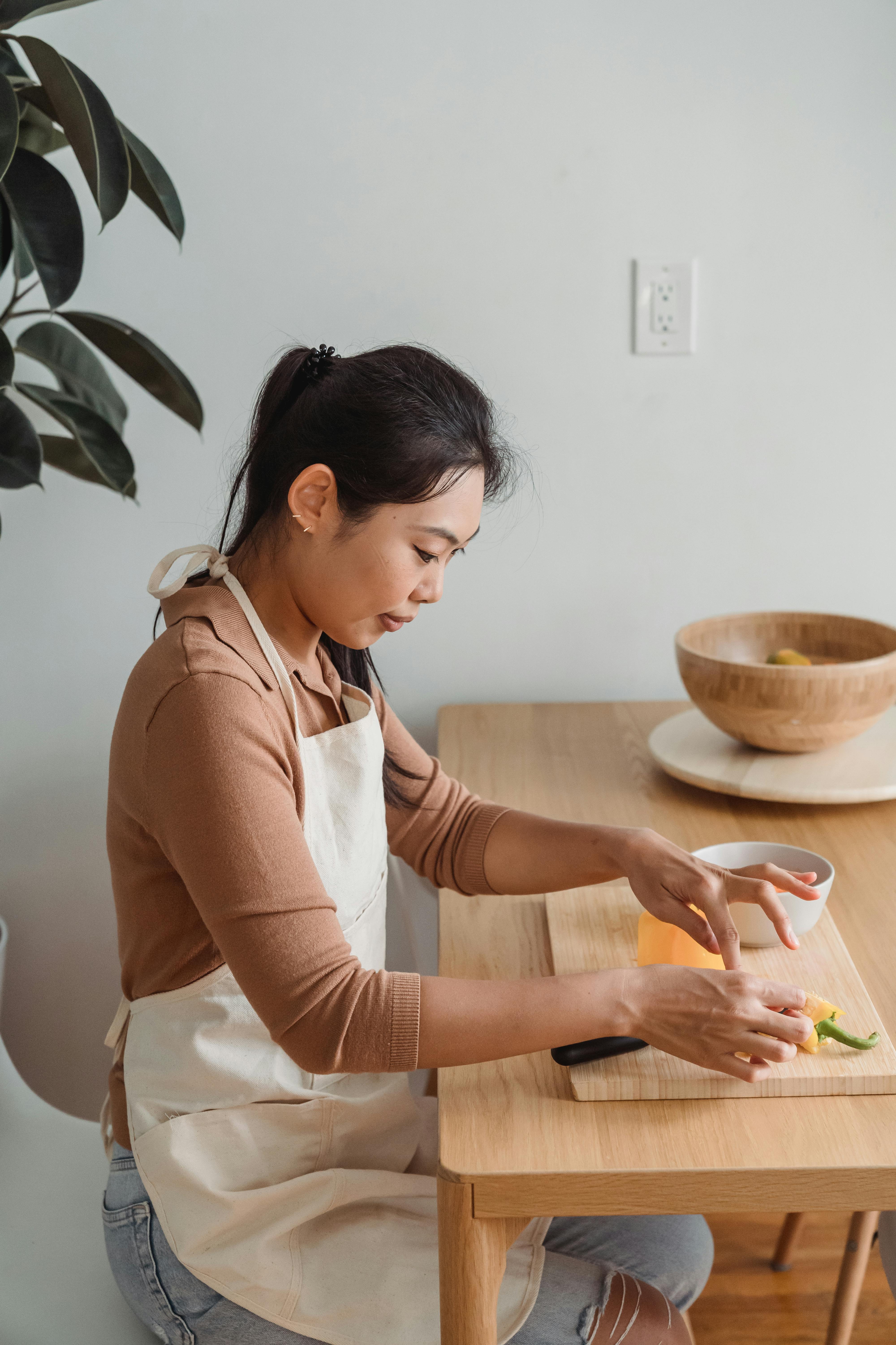 Woman Sitting by a Table and Preparing Food · Free Stock Photo