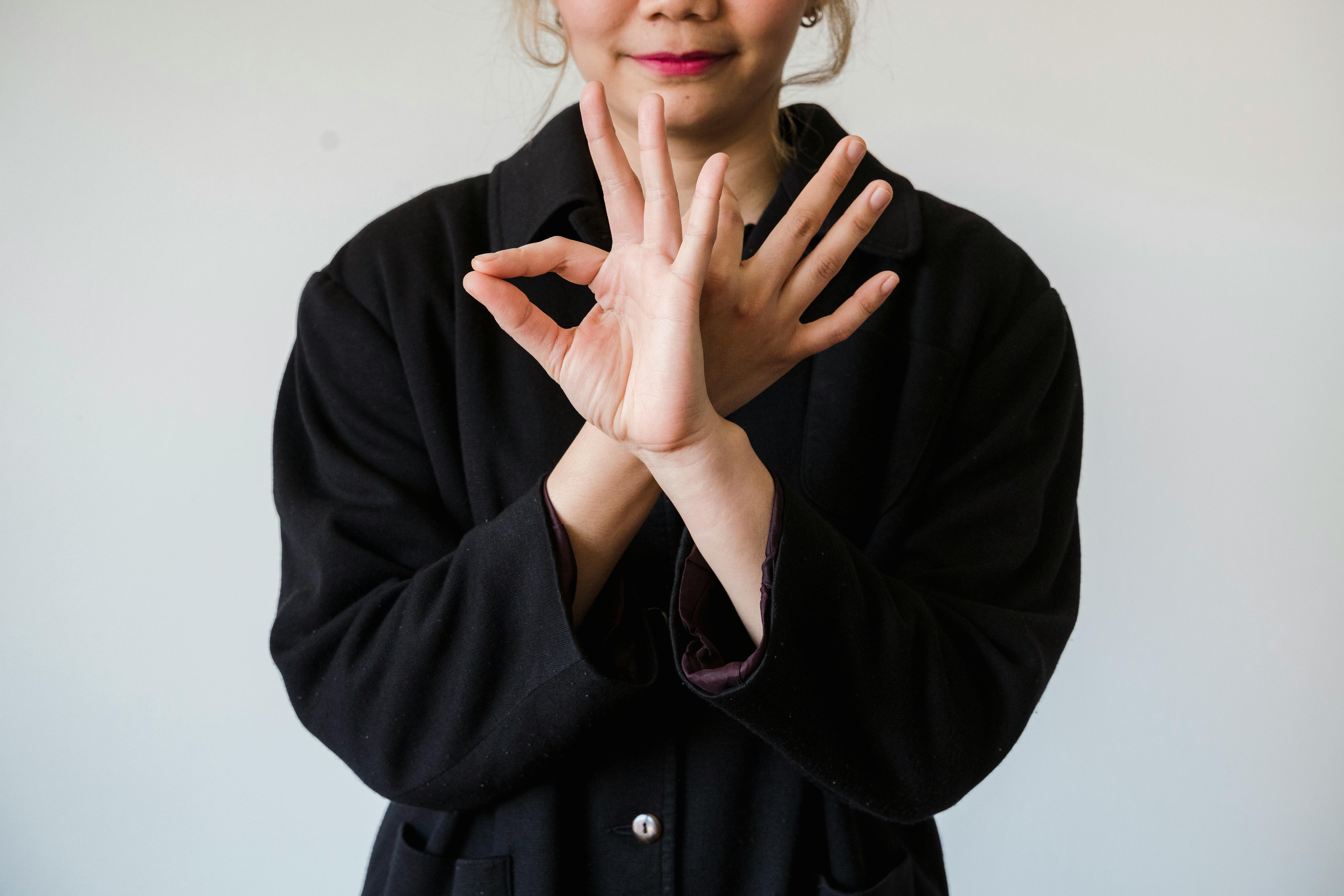 A Woman in Black Coat Making Hand Sign · Free Stock Photo