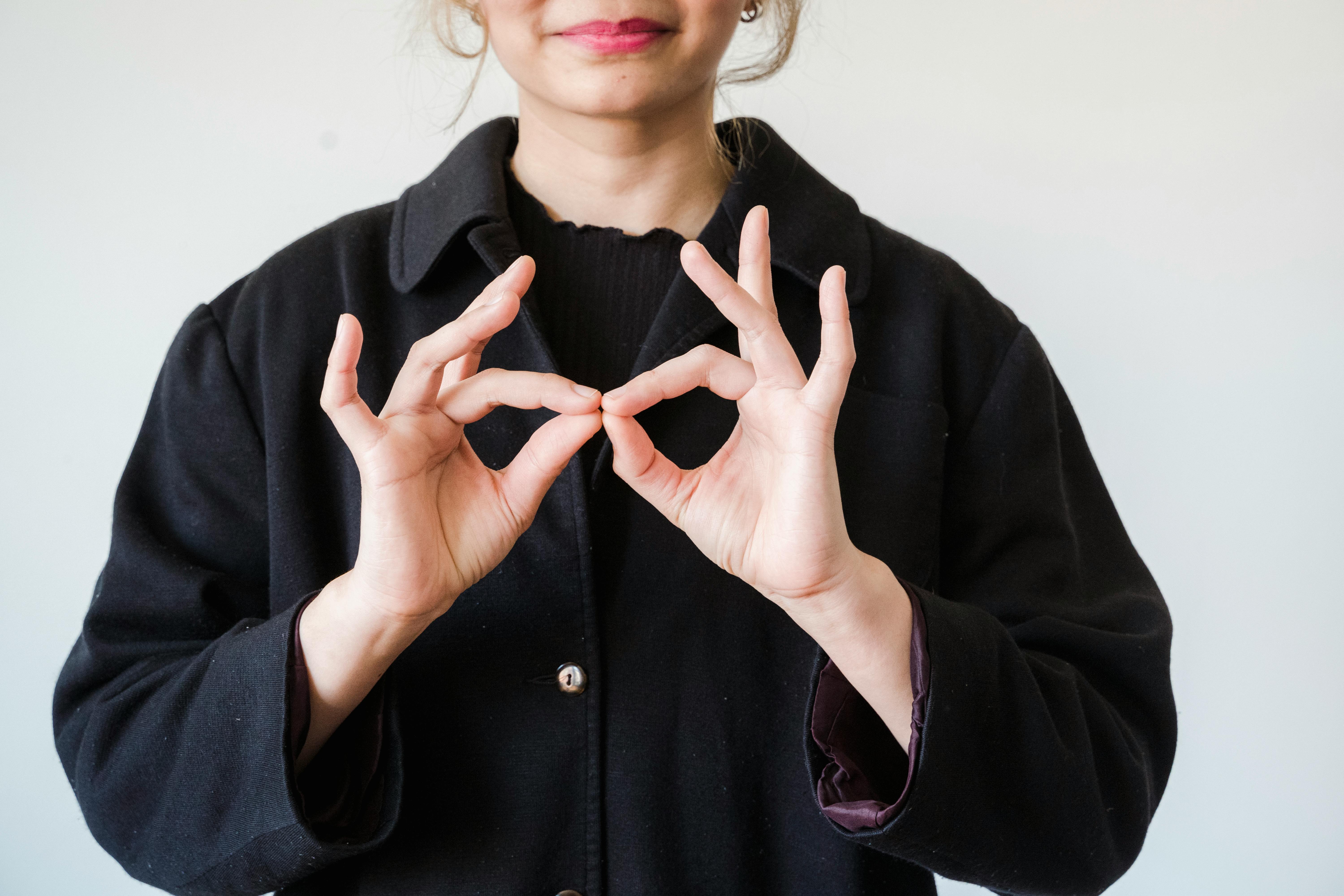 A Person in Black Coat doing Sign Language · Free Stock Photo