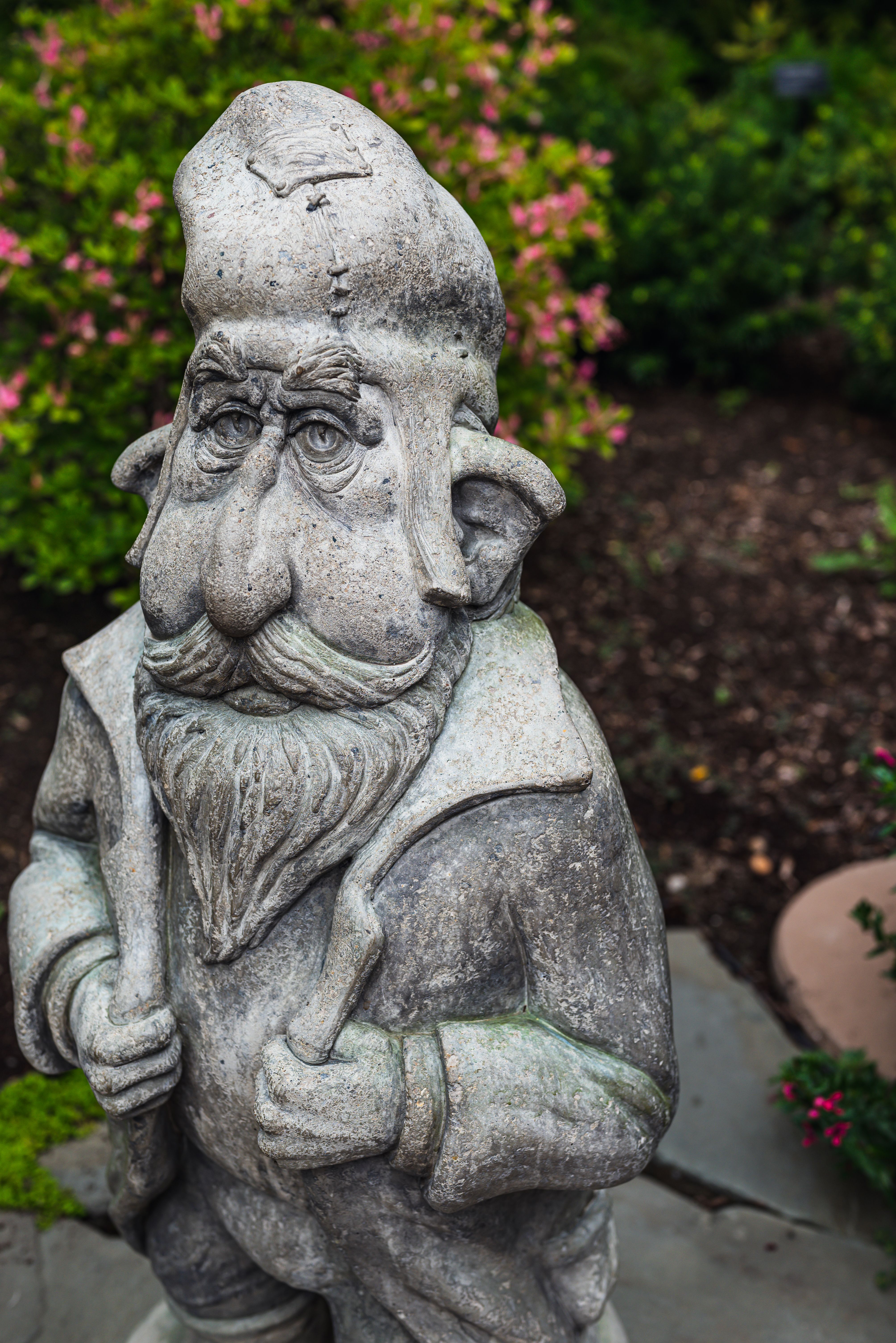 Gray Dwarf Concrete Statue Near Green Plants · Free Stock Photo