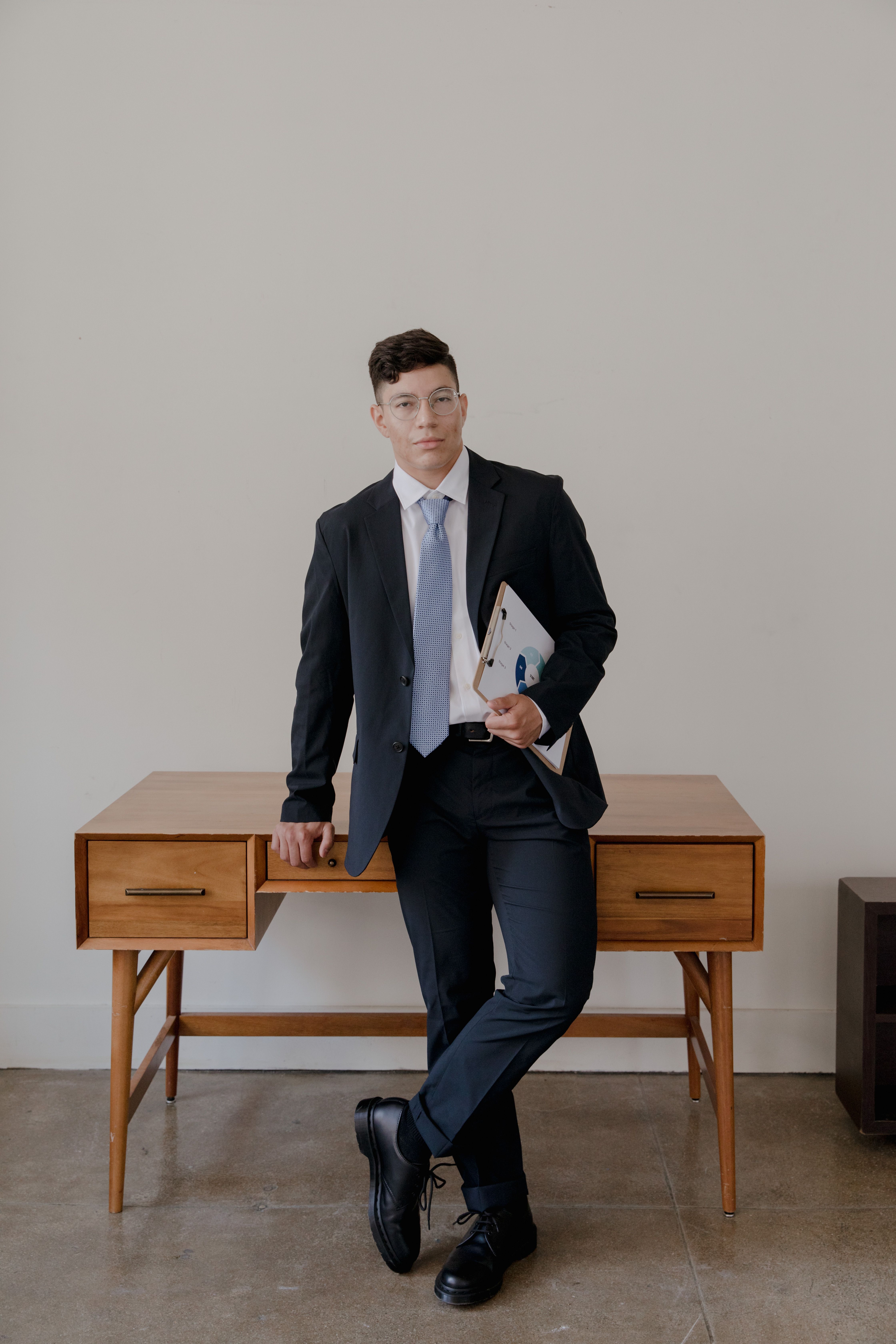 Man in Black Suit Standing beside Wooden Table · Free Stock Photo