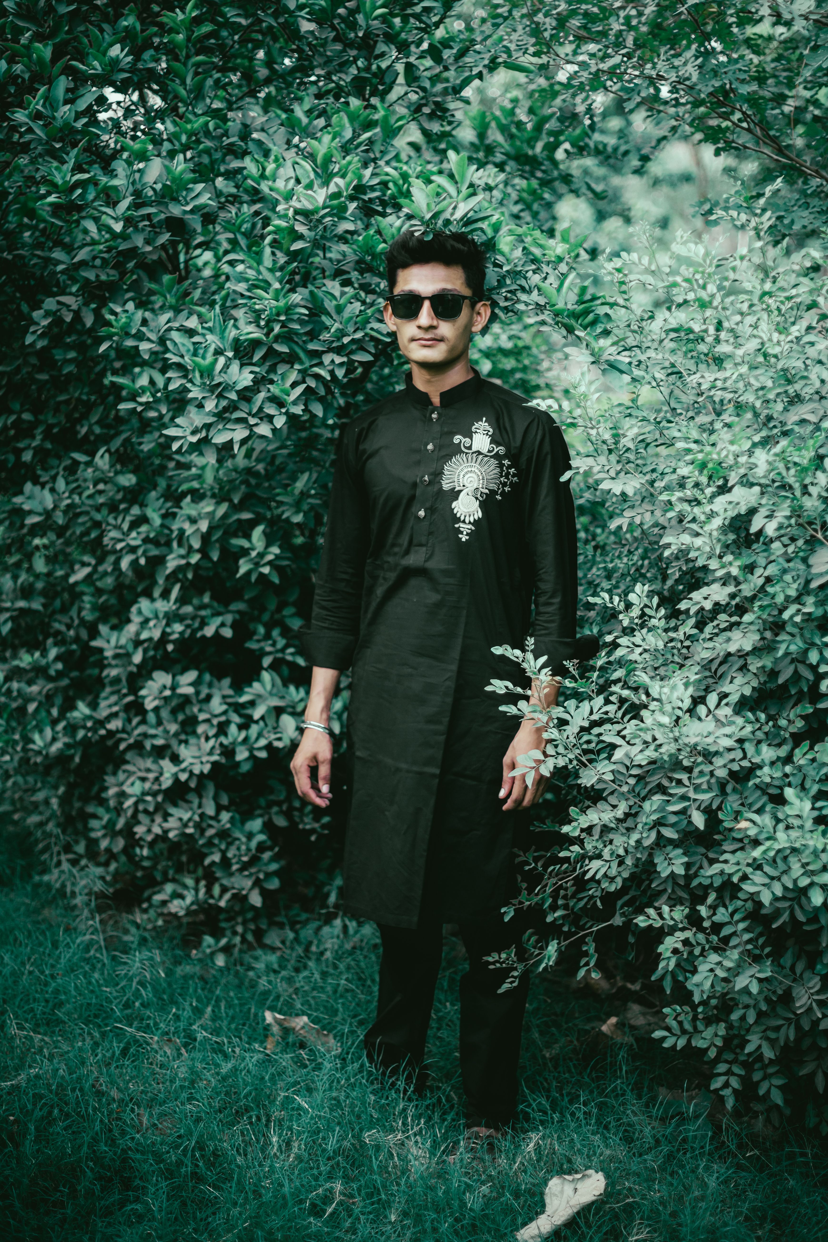 Man in Dark Green Traditional Clothing Standing near the Green Plants ...