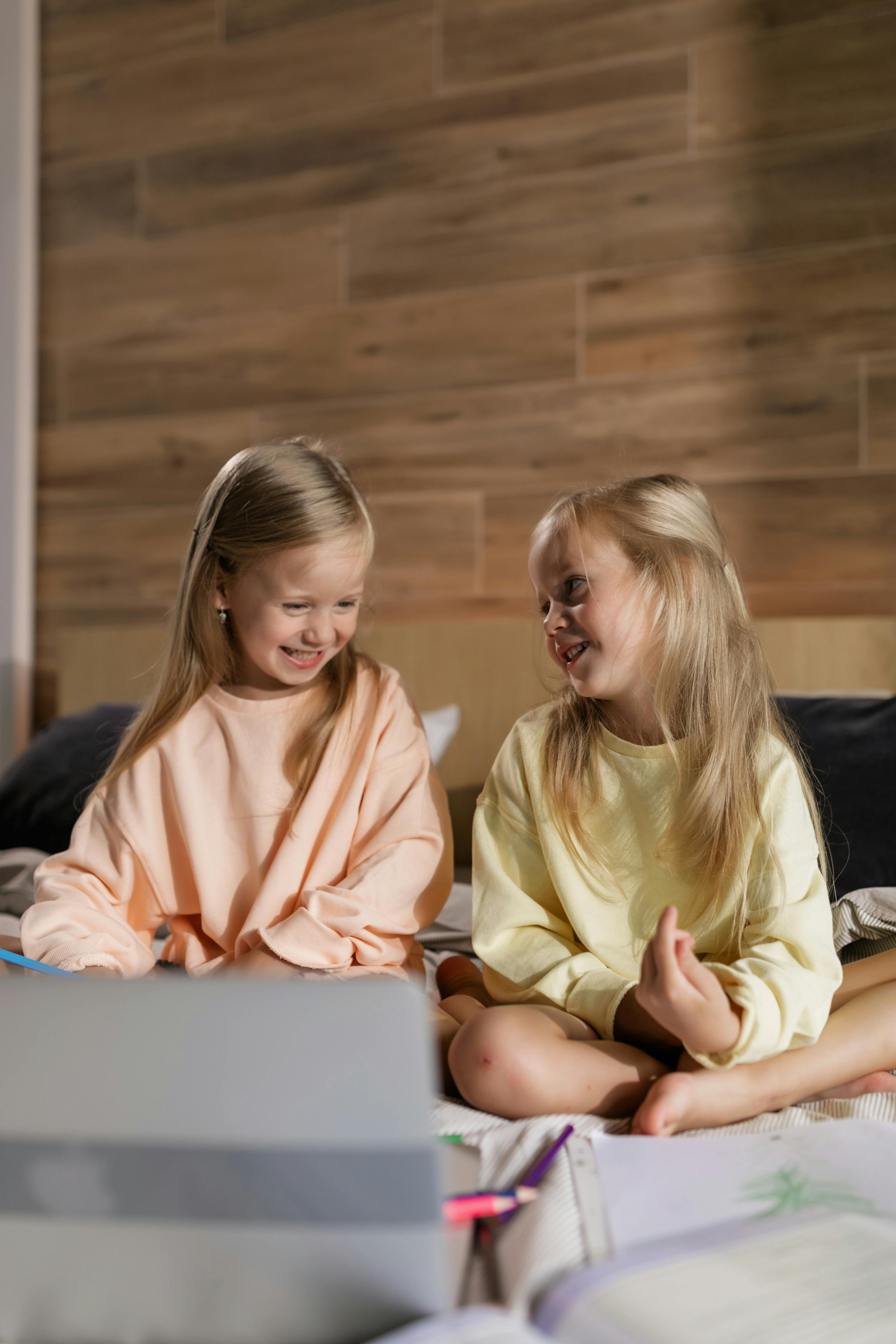 Girl in Yellow Sweater Sitting beside a Girl in Orange Sweater Smiling ...