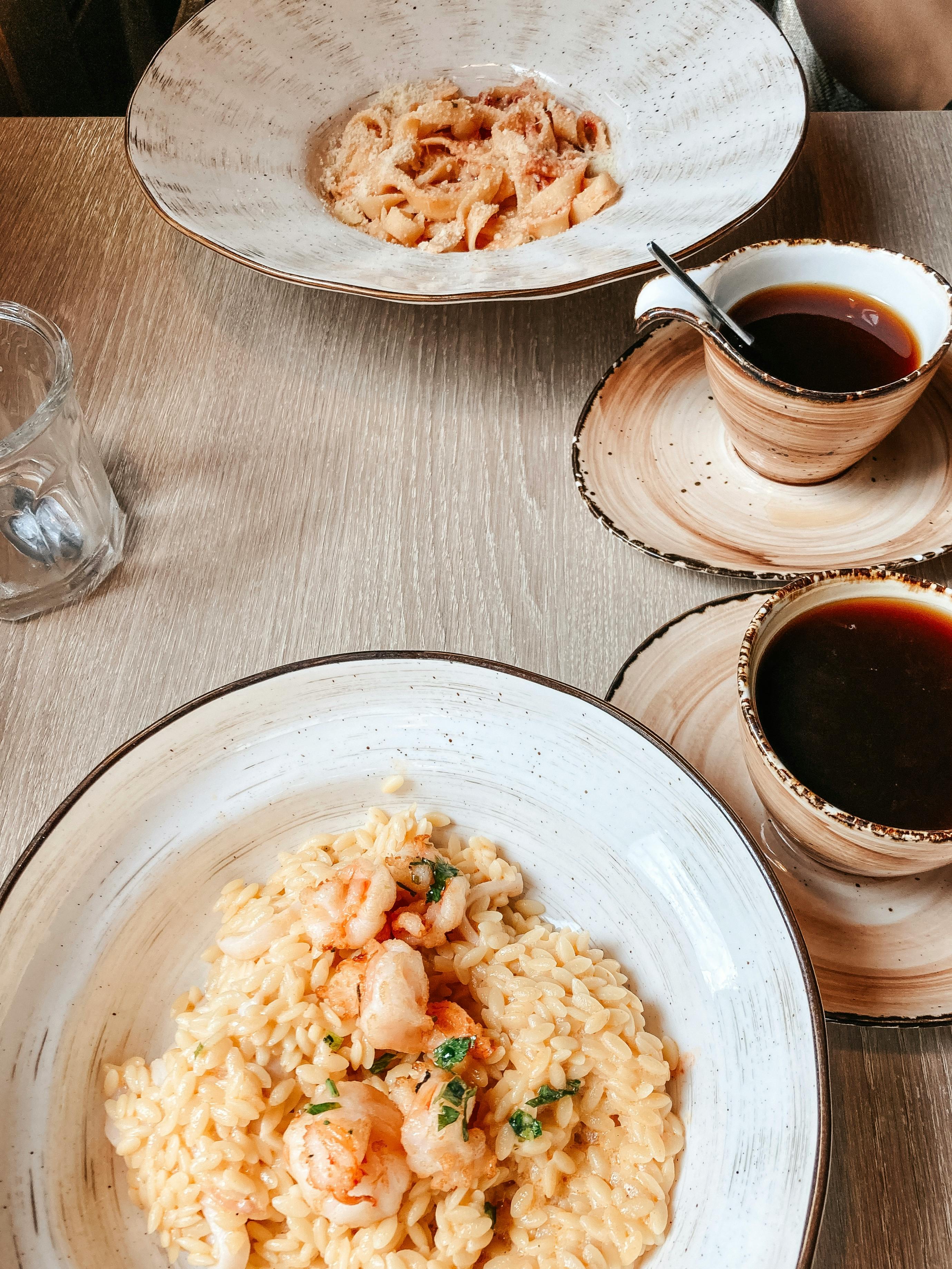 A Plate with Risotto and a Bowl with Pasta on the Wooden Table · Free ...