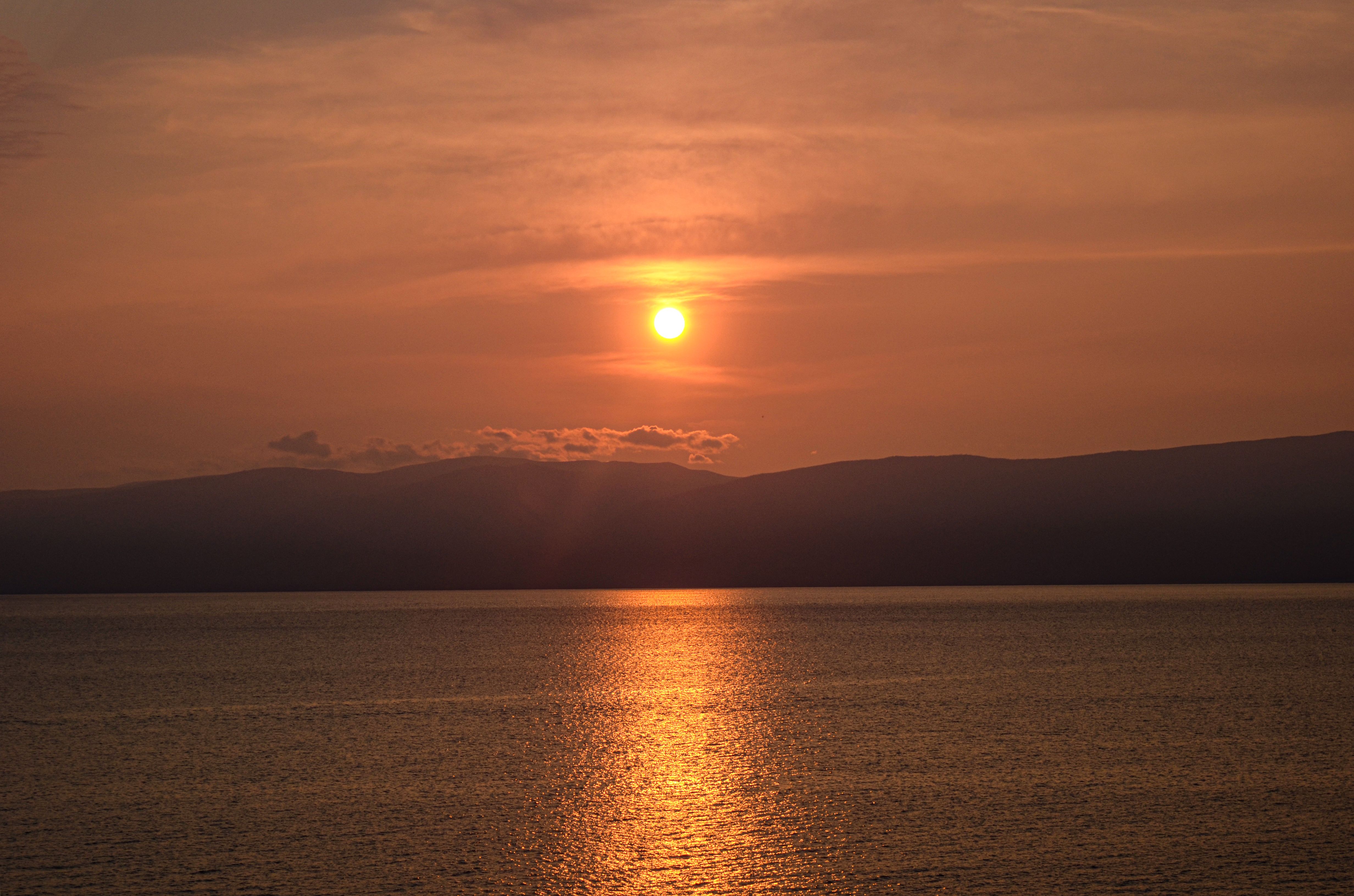 Ocean near Mountains during Sunset · Free Stock Photo