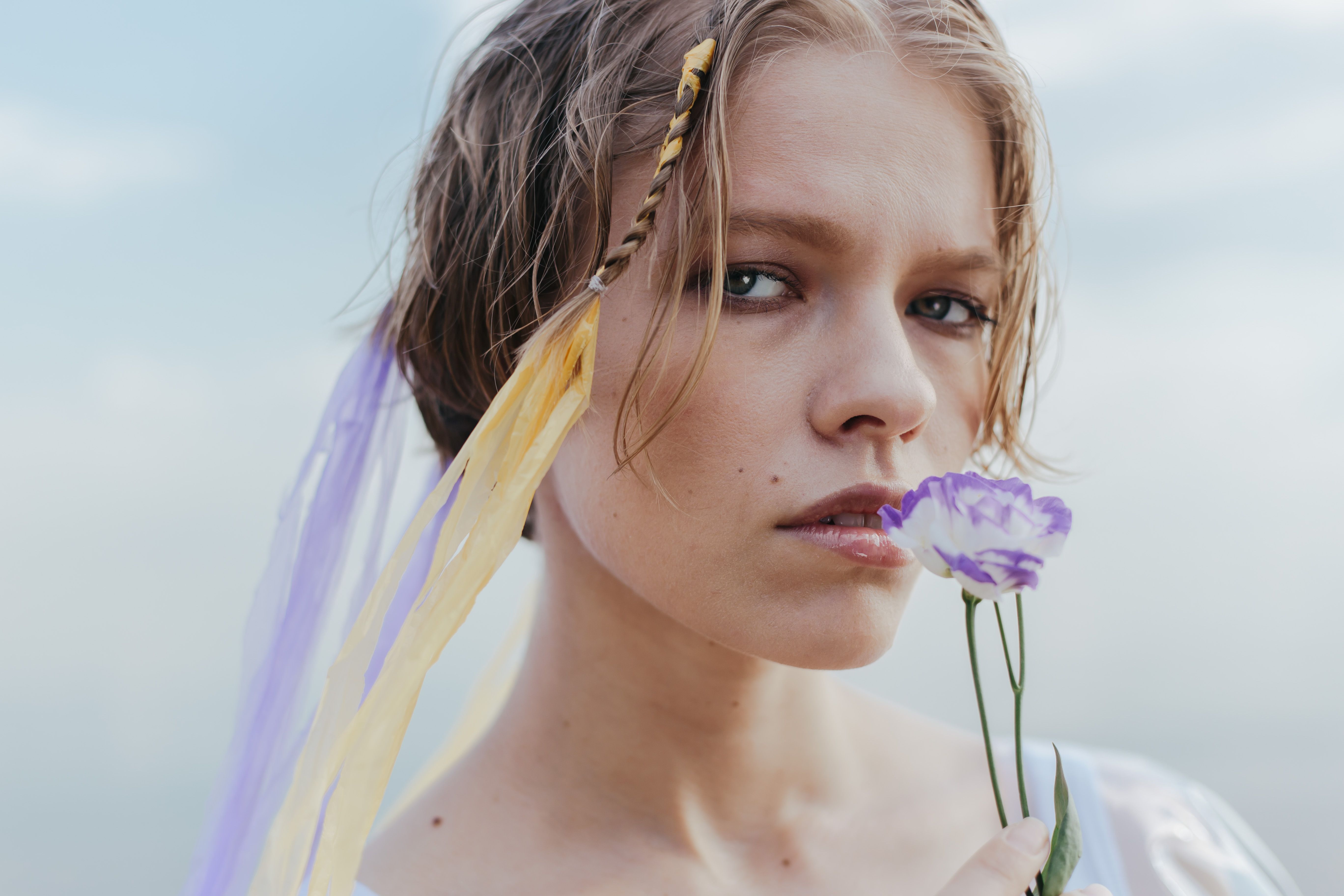 A Woman Holding a Purple Flower · Free Stock Photo
