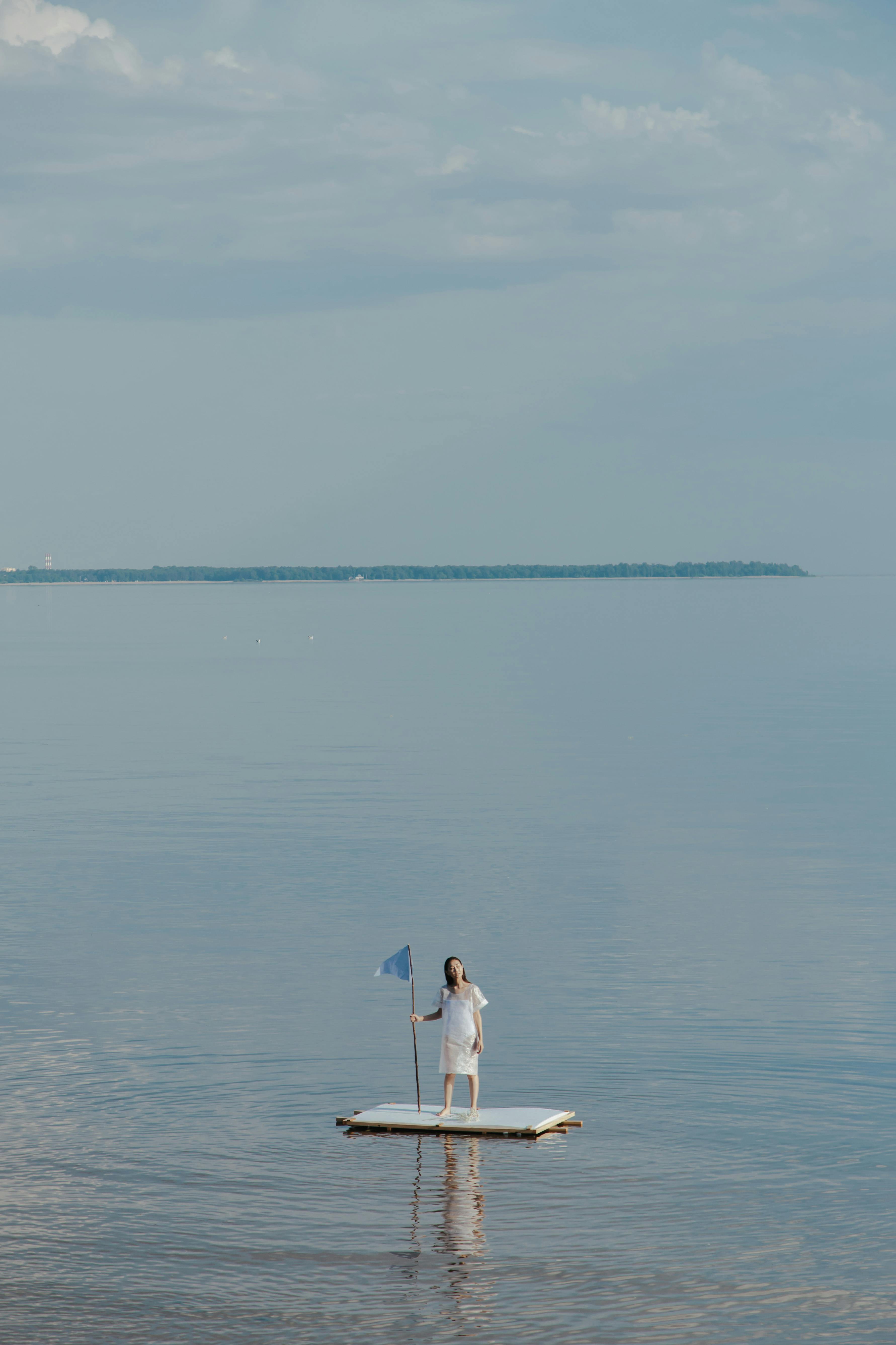 A Woman in White Dress Standing on a Raft · Free Stock Photo