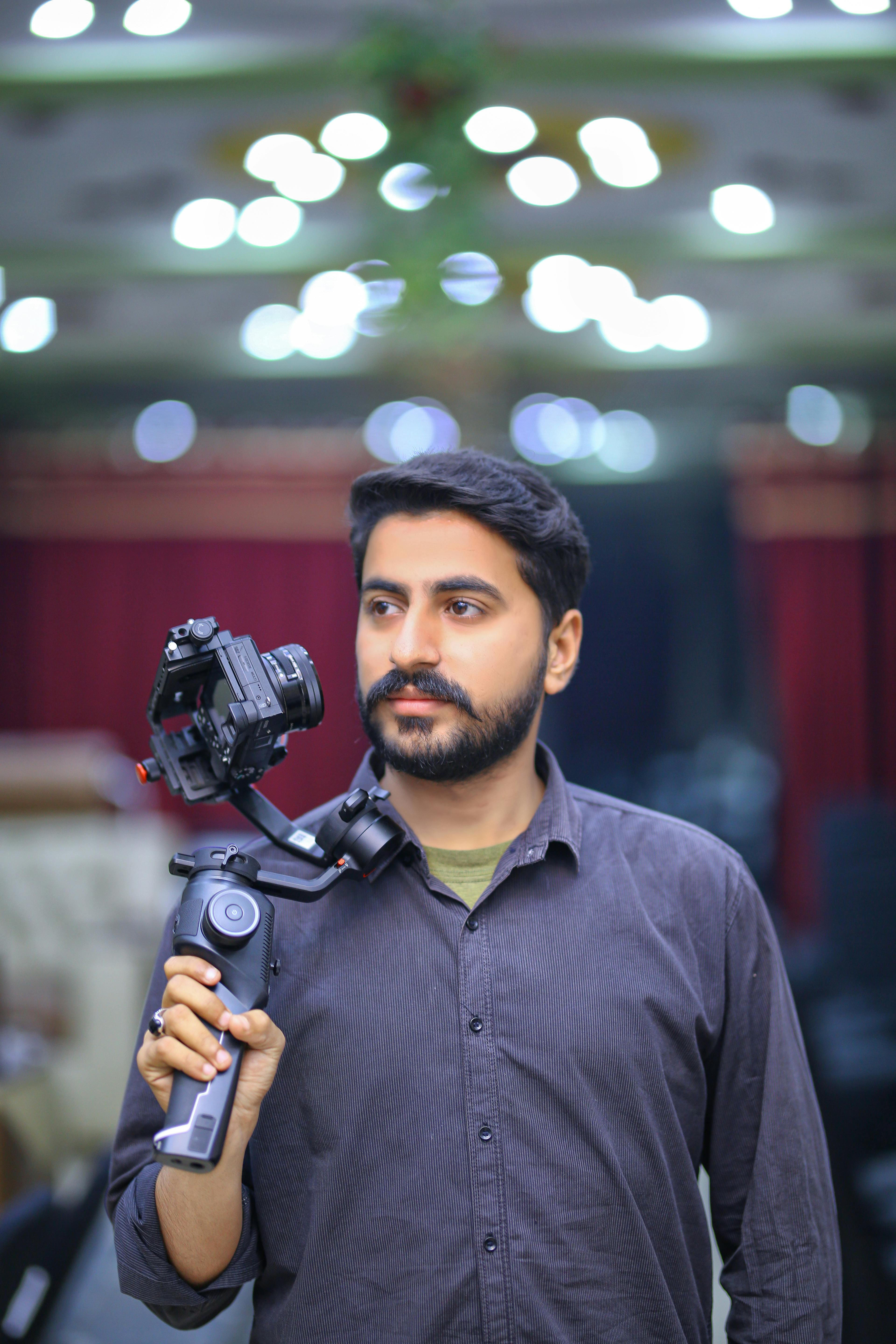 Man in Black Dress Shirt Holding Black Camera · Free Stock Photo