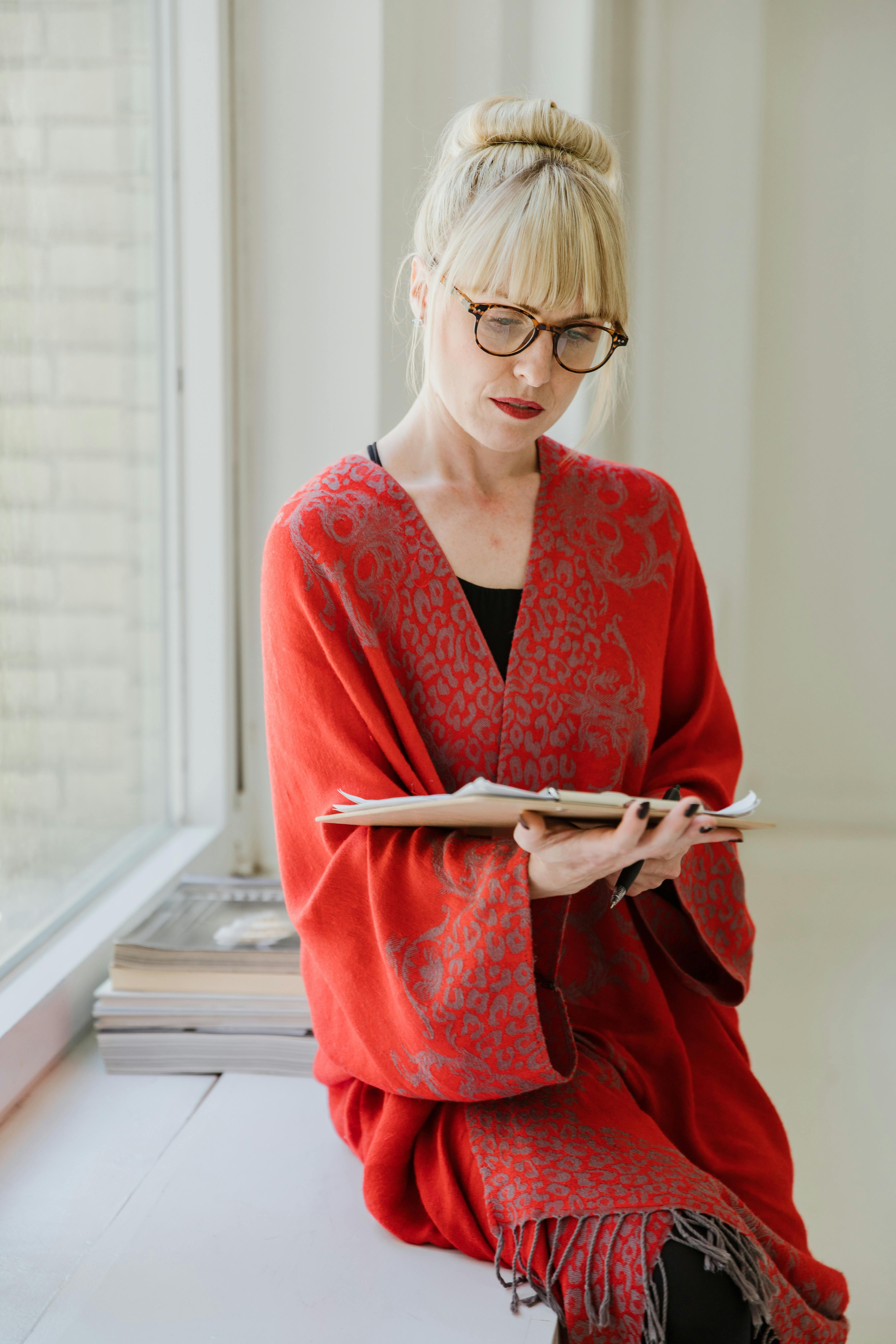 A Woman in a Red Robe Holding Books · Free Stock Photo
