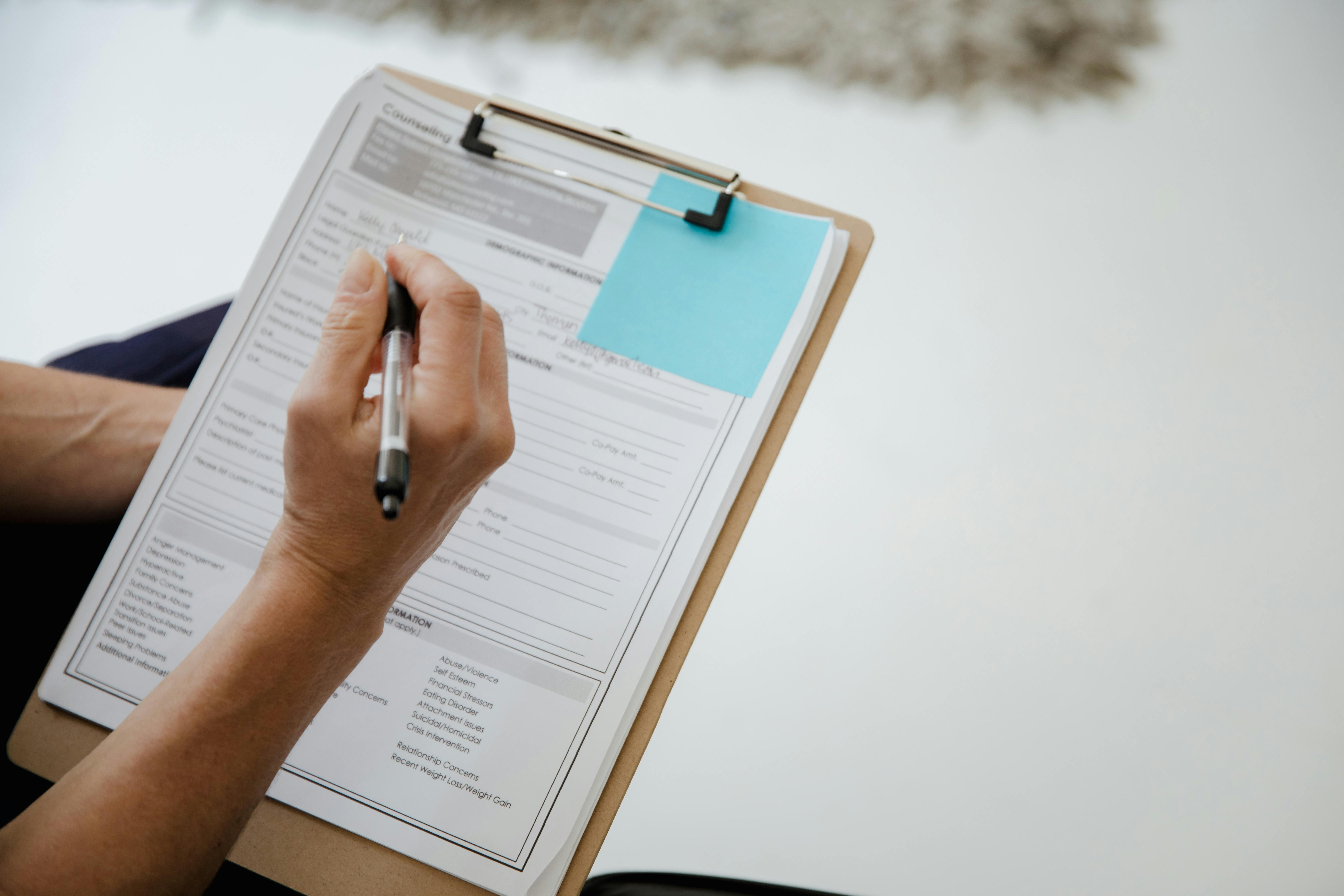 Close-Up Shot of a Person Holding a Clipboard · Free Stock Photo
