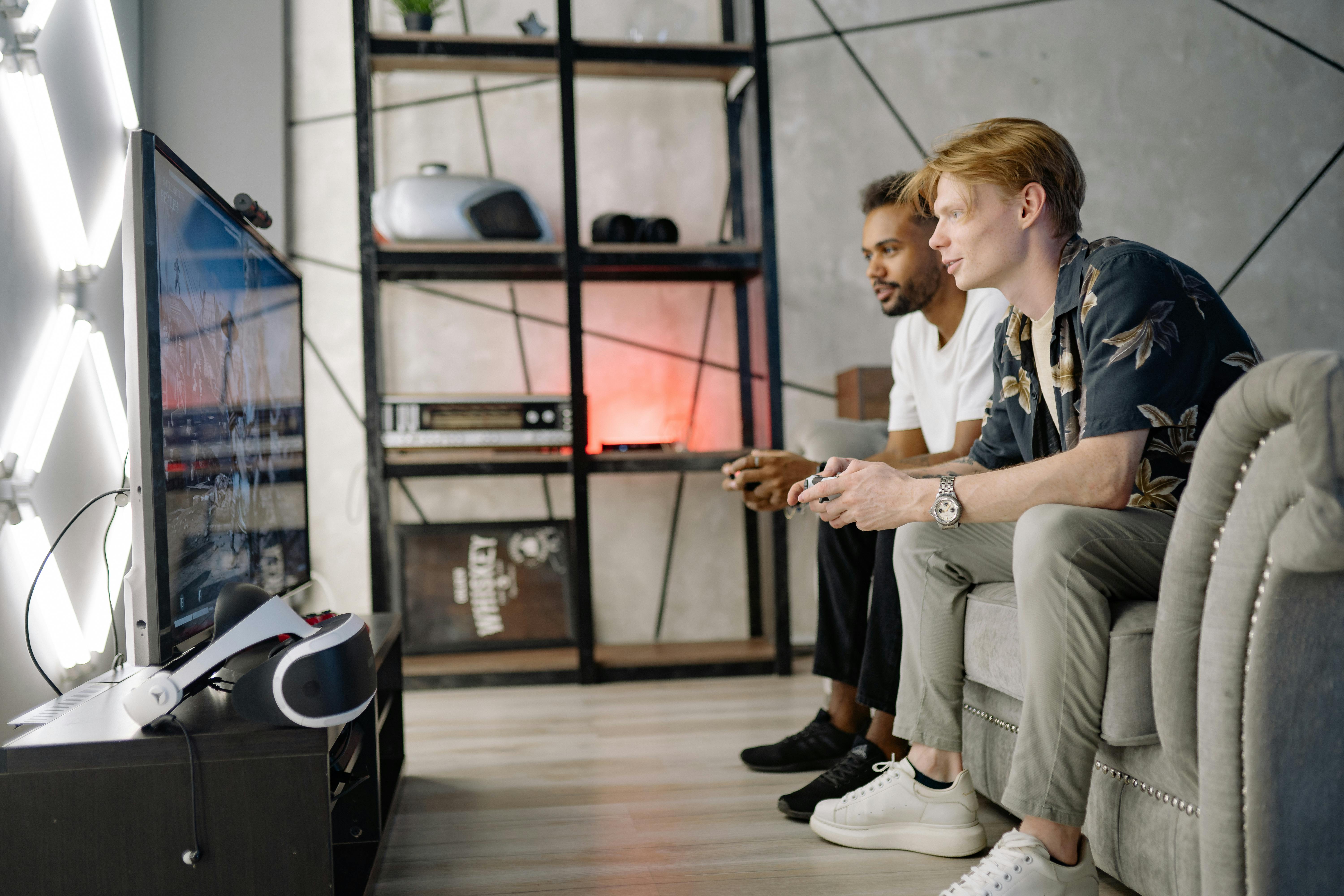 Two Men Playing Video Games while Sitting on the Sofa · Free Stock Photo