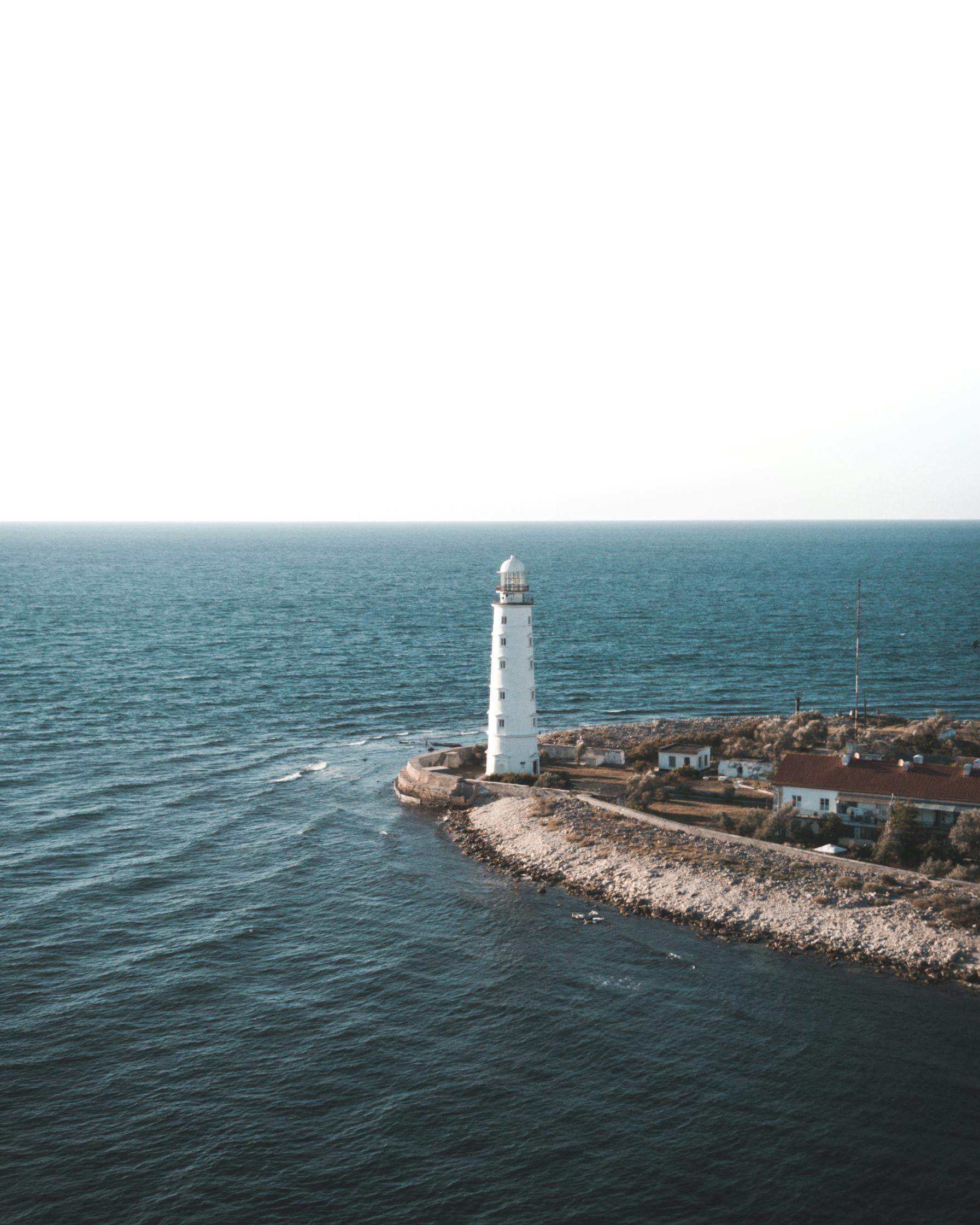 Aerial View of a White Lighthouse near the Sea · Free Stock Photo