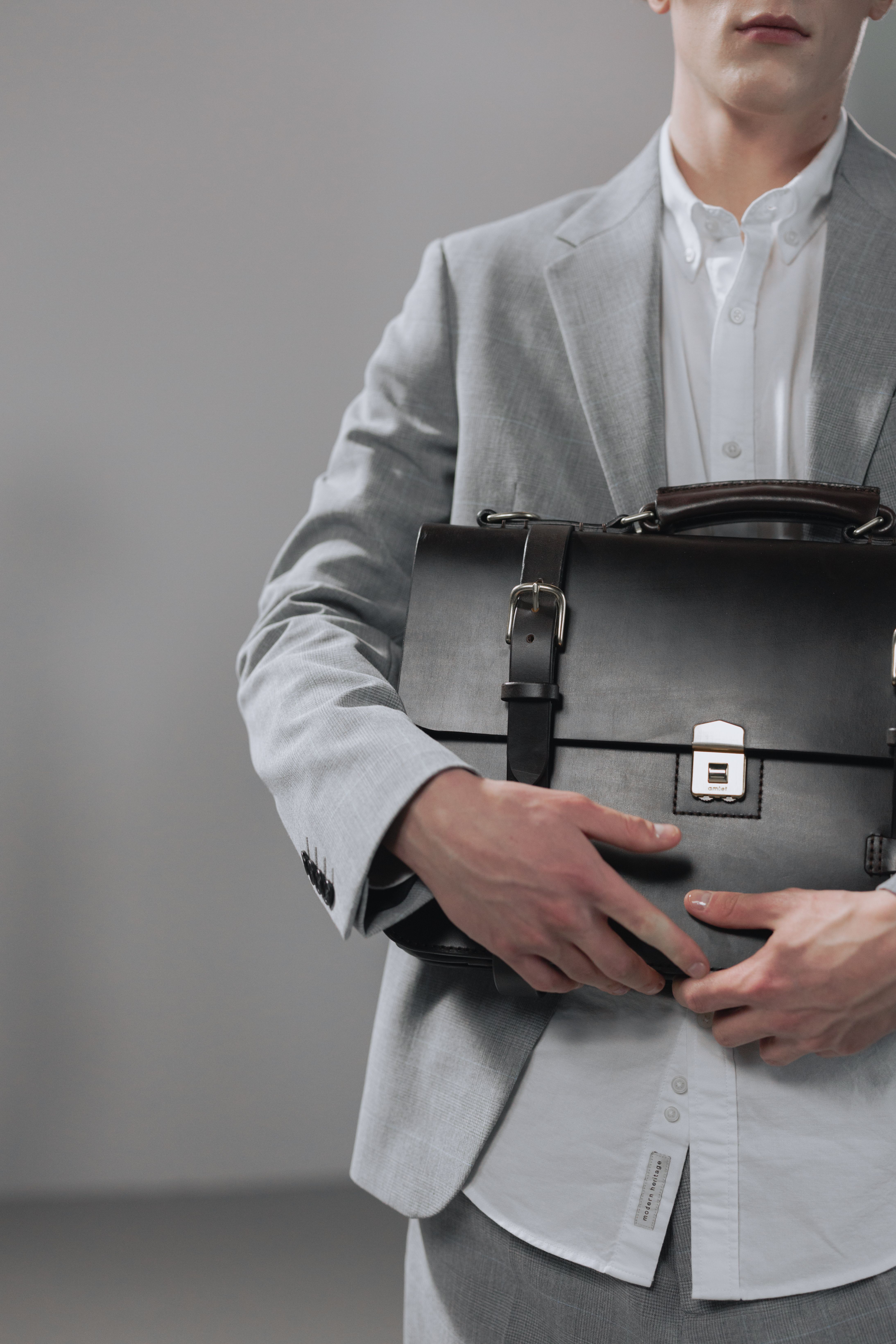 Man in Gray Suit Jacket Carrying Black Leather Briefcase · Free Stock Photo
