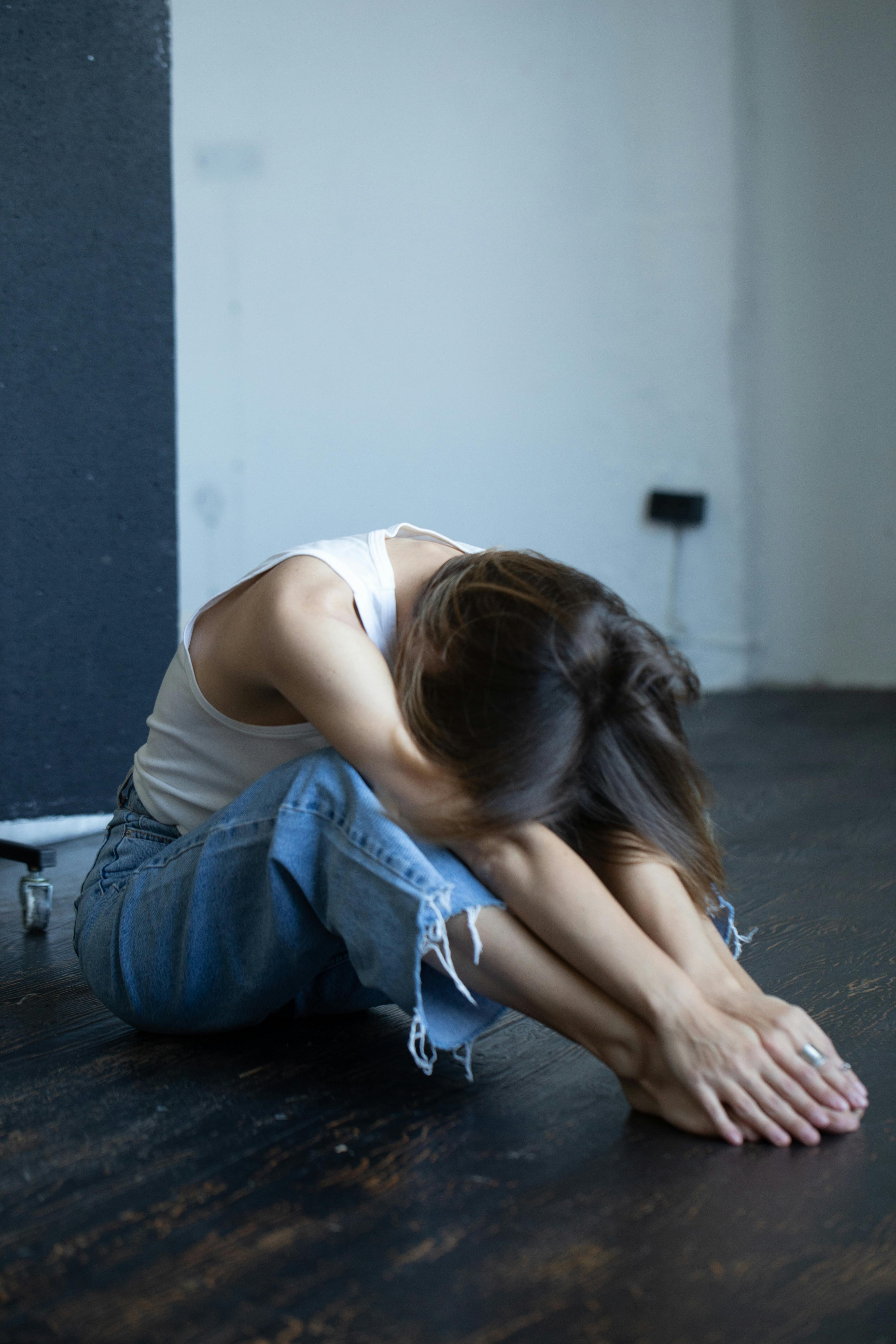 A Person Sitting on the Floor while Wearing Jeans · Free Stock Photo
