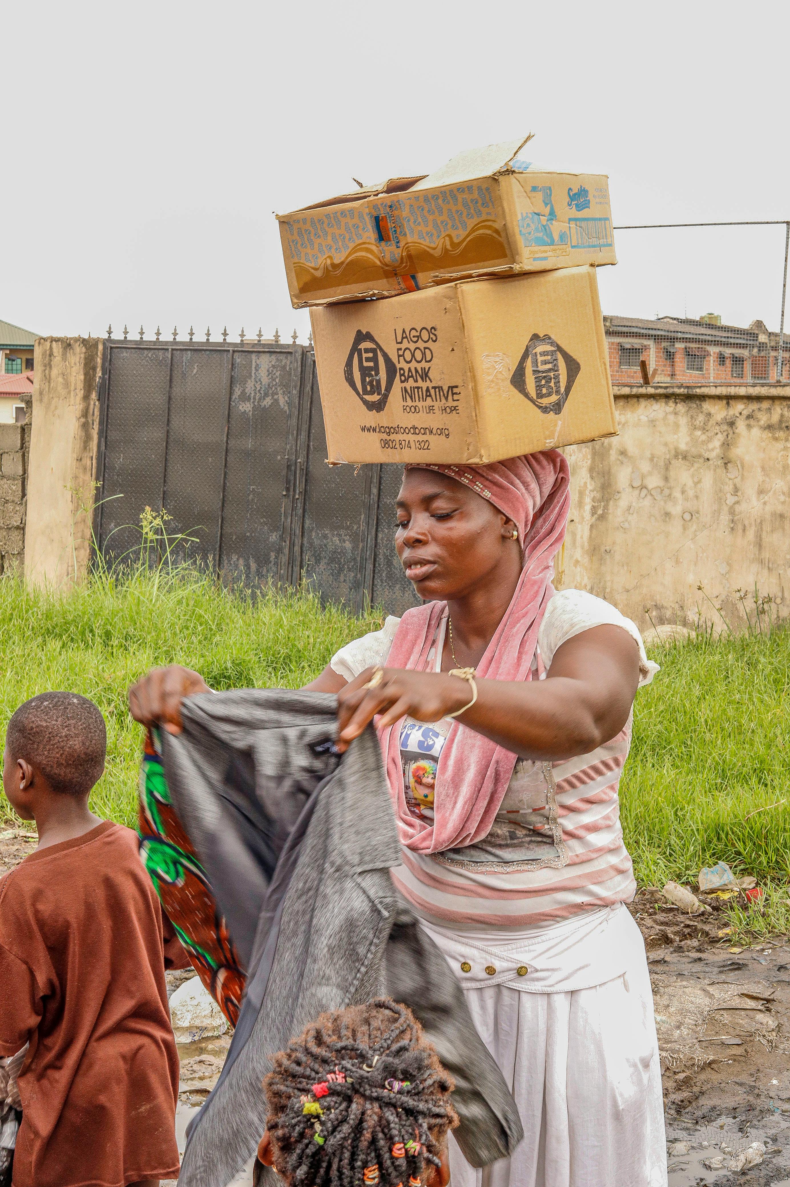 A Person in Black and Gray Jacket Handing Over Boxes to a Person · Free ...