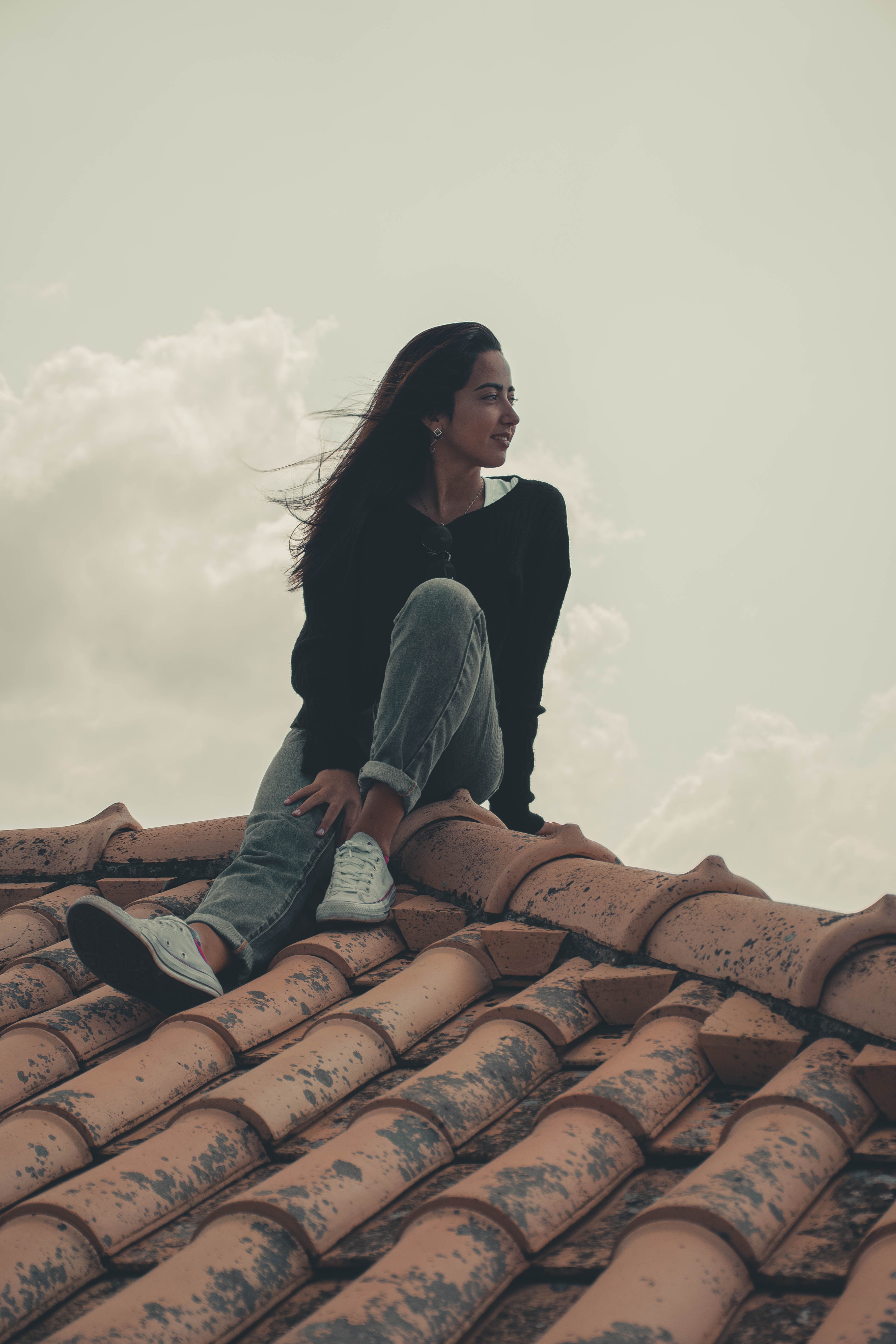 A Woman Sitting on Top of the Roof · Free Stock Photo
