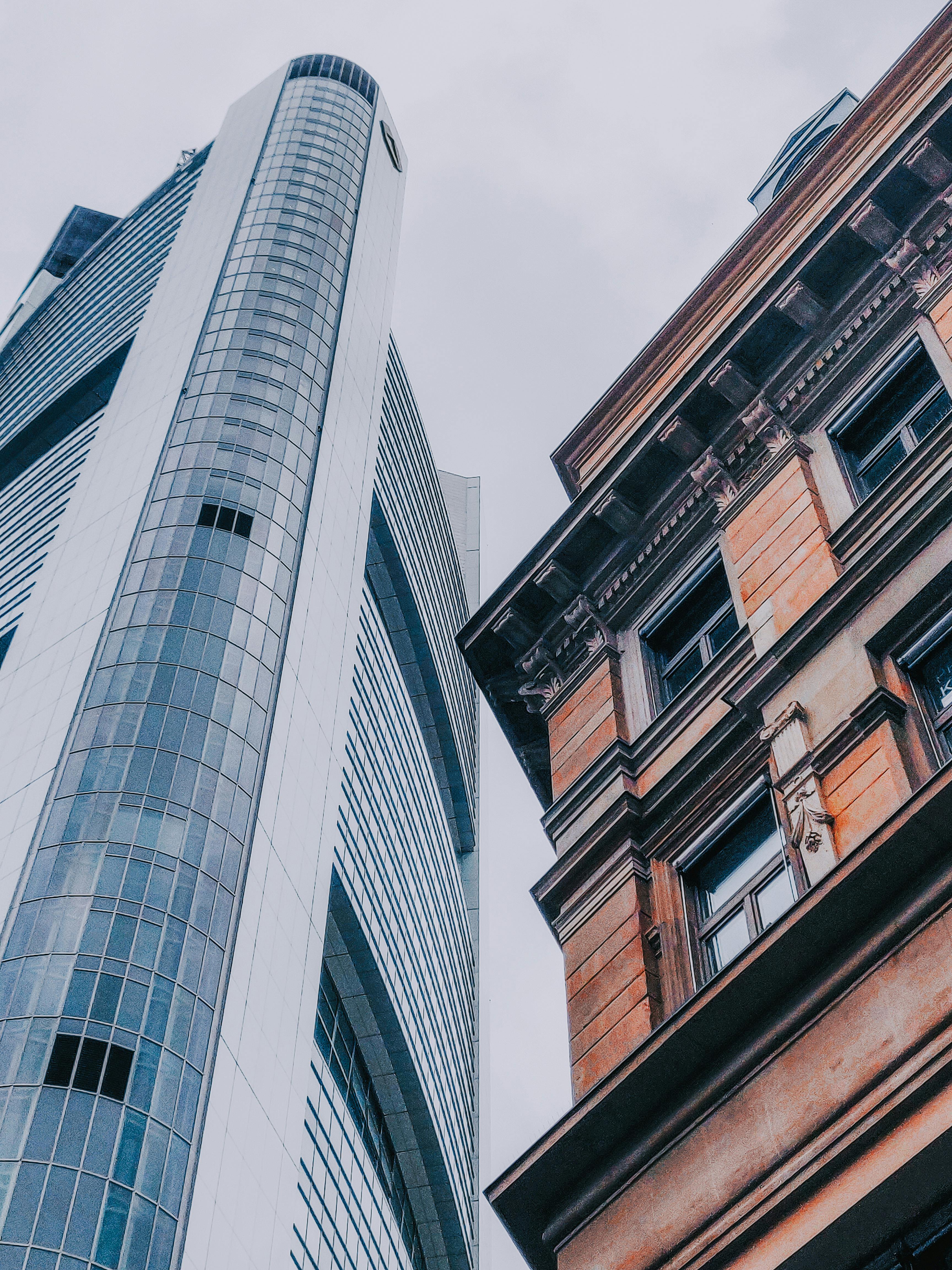 Low-Angle Shot of a High Rise Building and a Concrete Building · Free ...