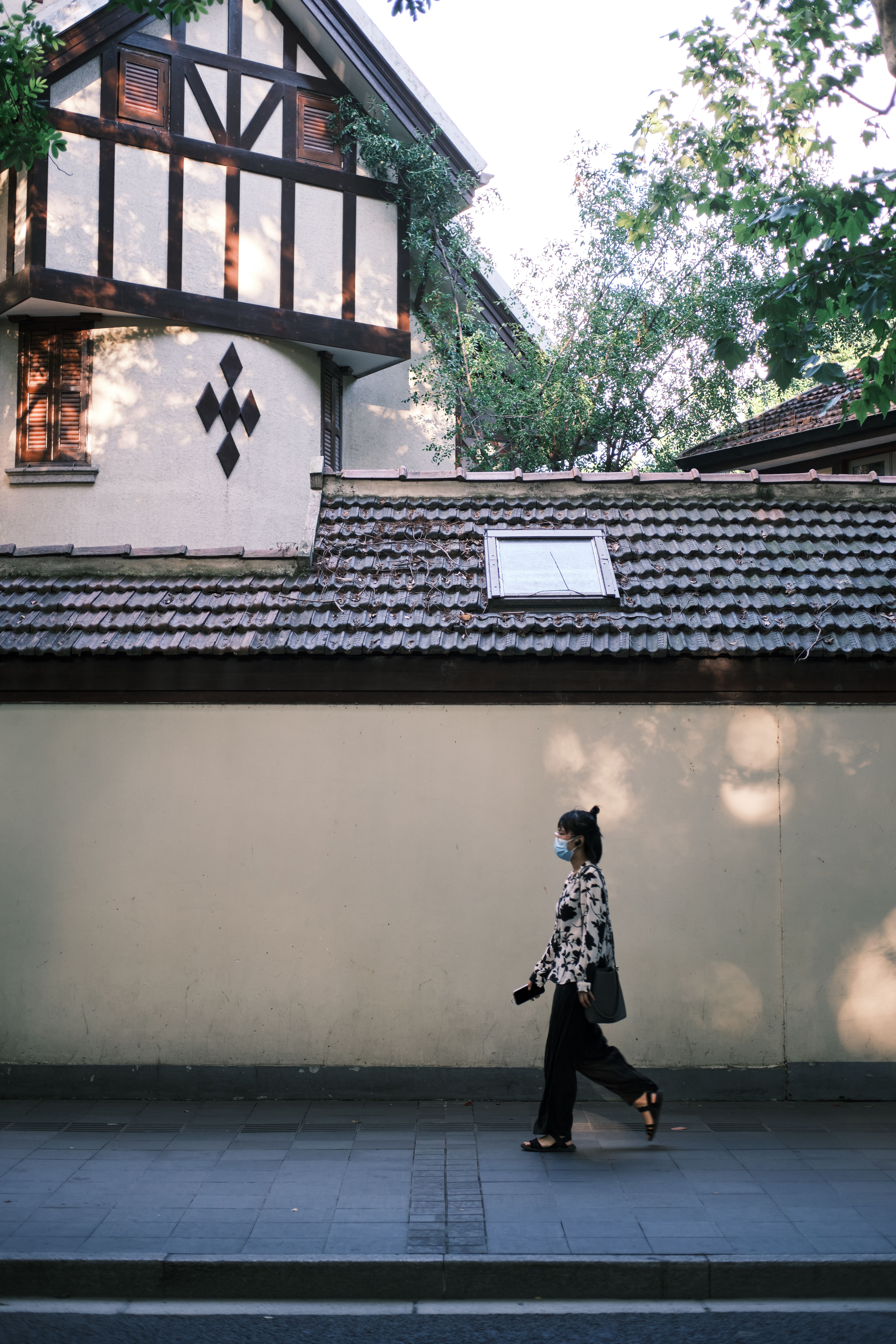 A Woman Wearing a Face Mask Walking on a Sidewalk · Free Stock Photo