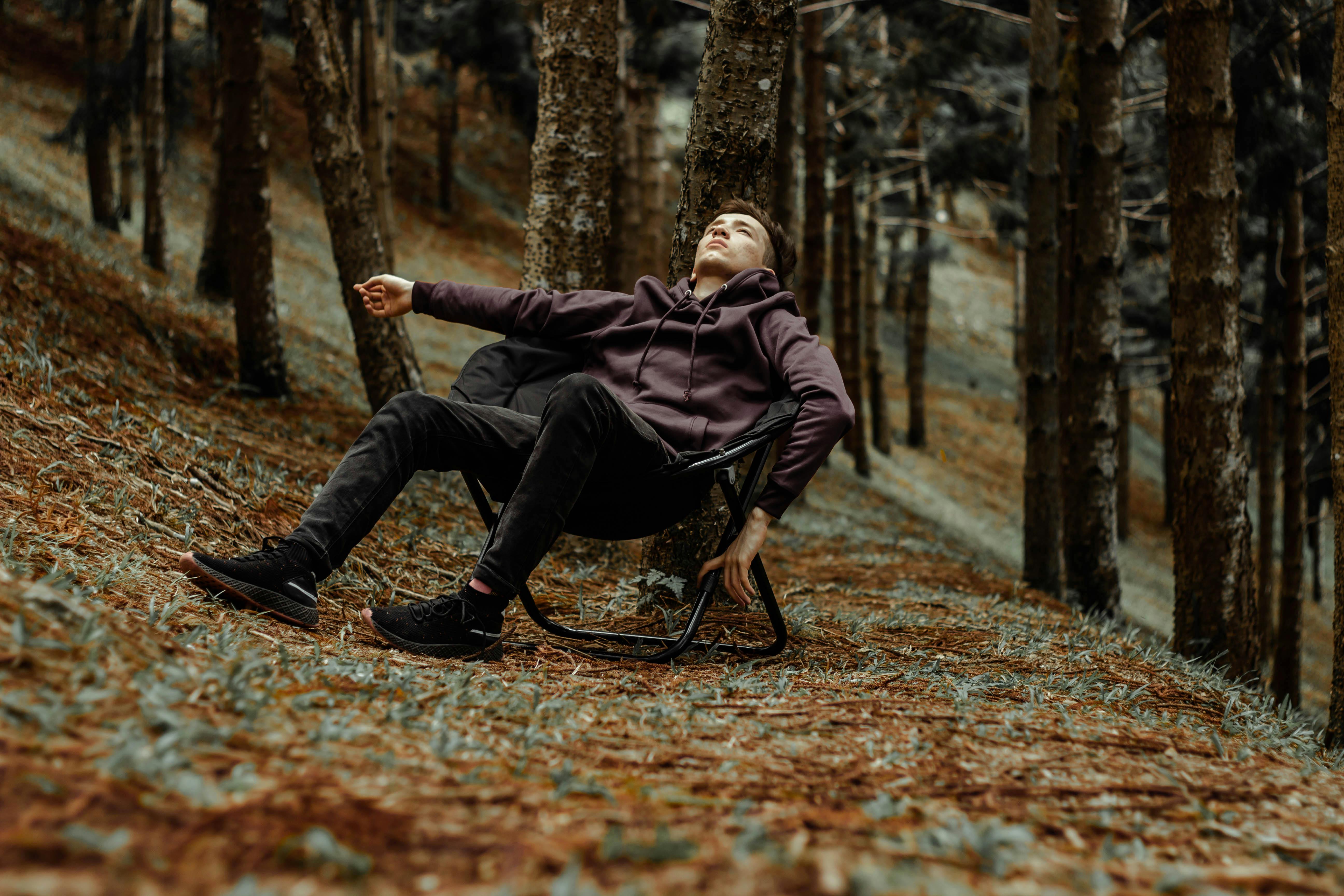 Young Man Sitting in the Folding Chair in Woods · Free Stock Photo