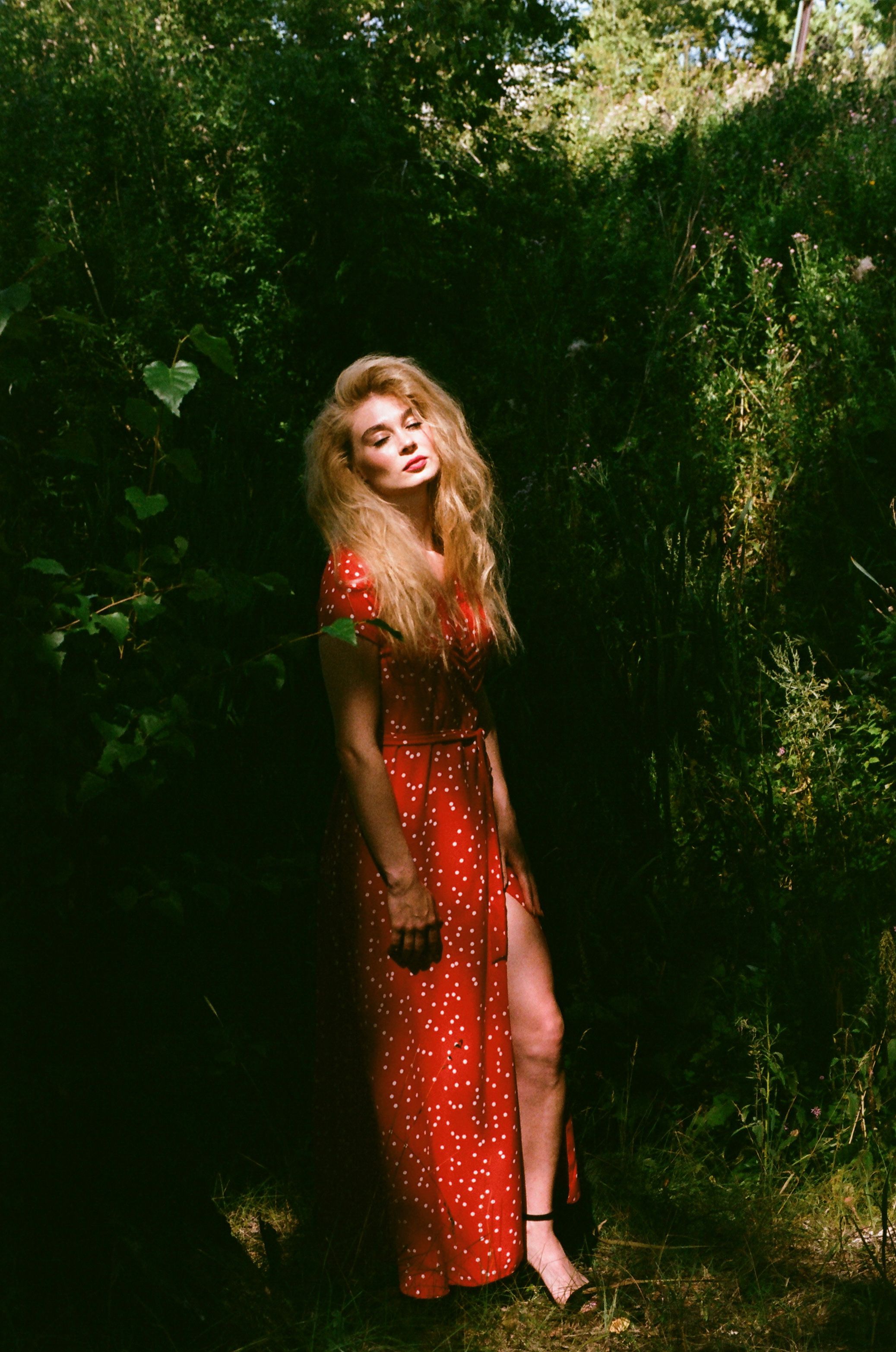 A Woman in Red Dress Standing between the Bushes · Free Stock Photo