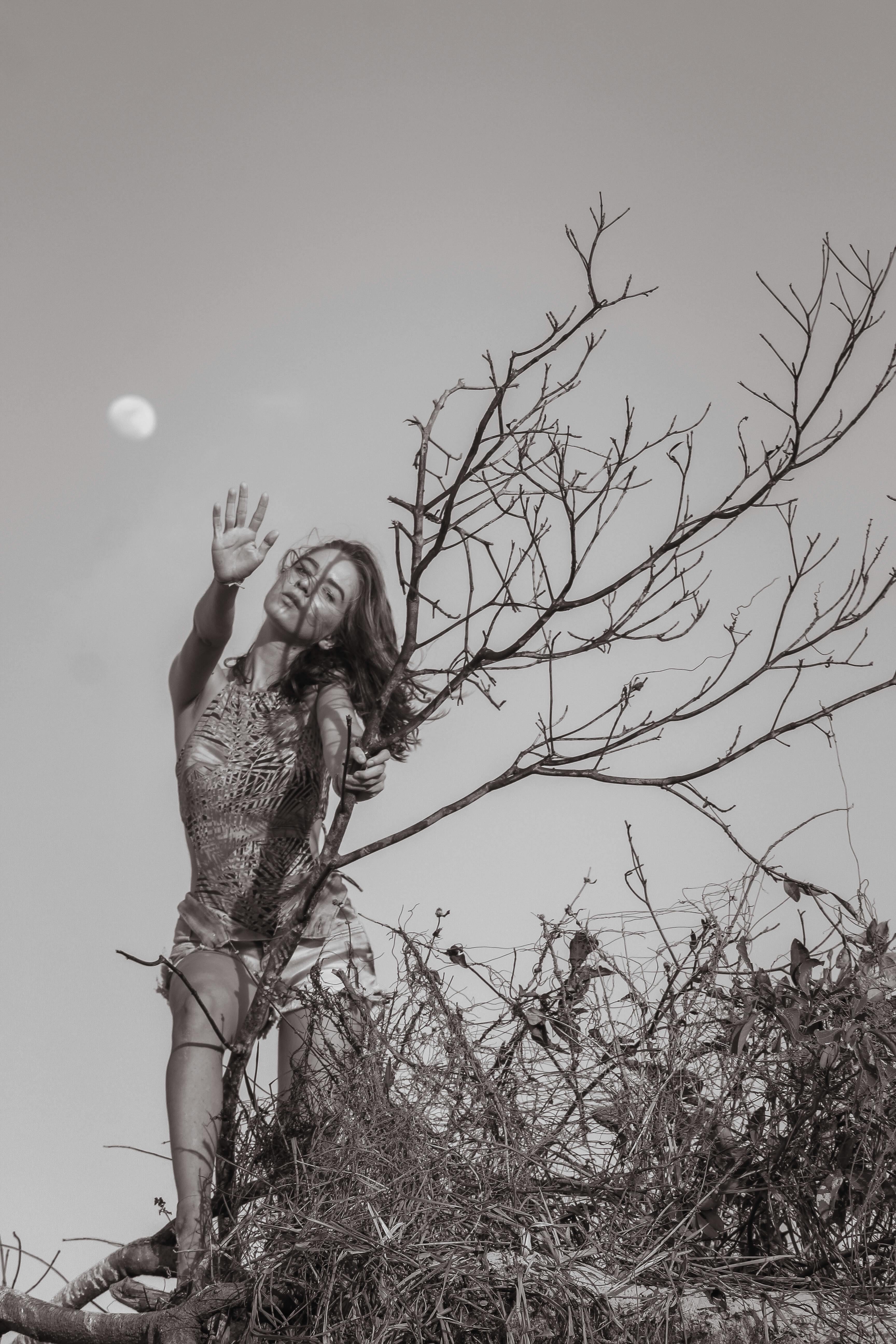 Grayscale Photo of a Woman with a White Shawl Standing Near the Bushes ...
