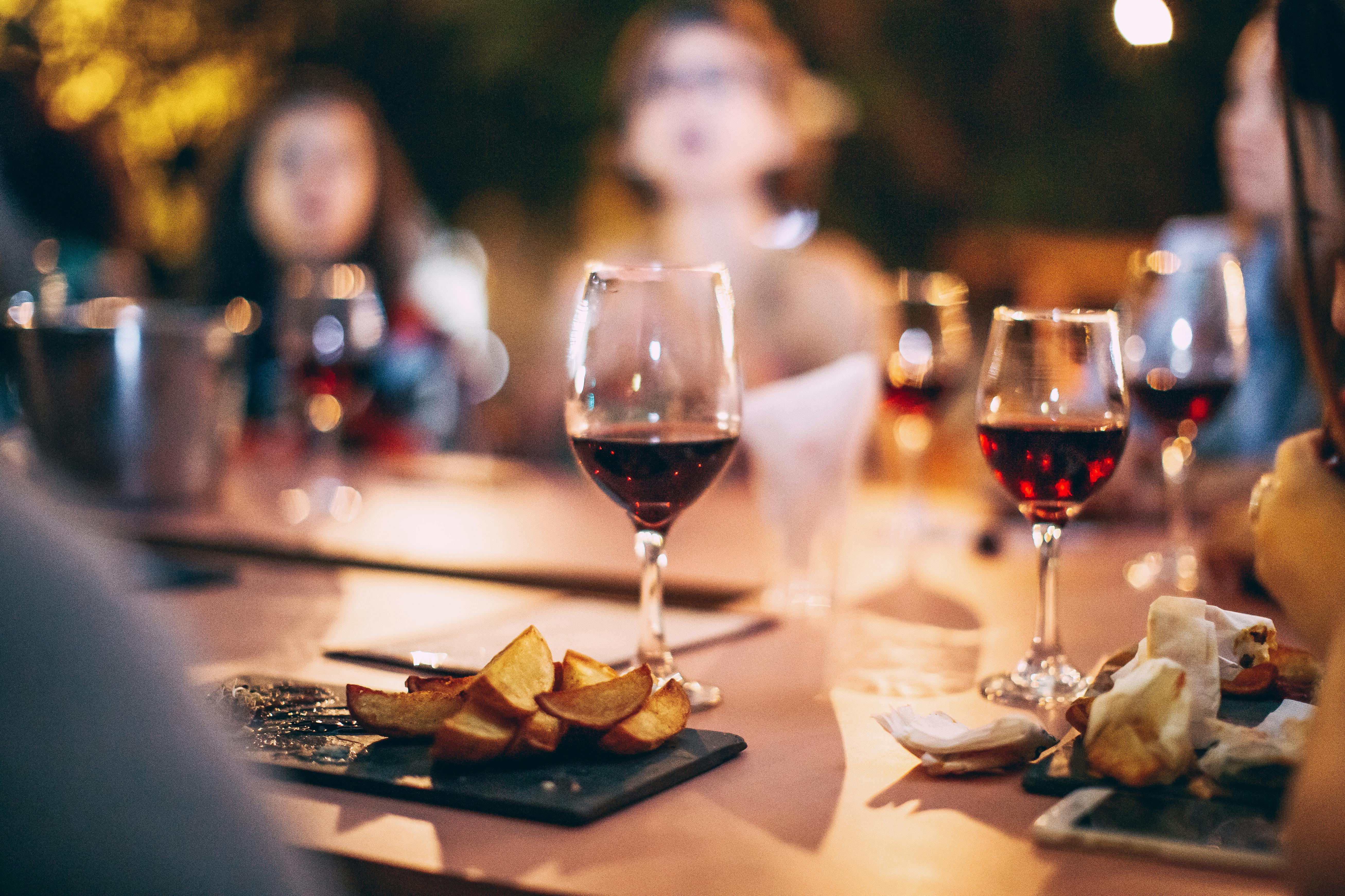 People Drinking Liquor and Talking on Dining Table Close-up Photo ...