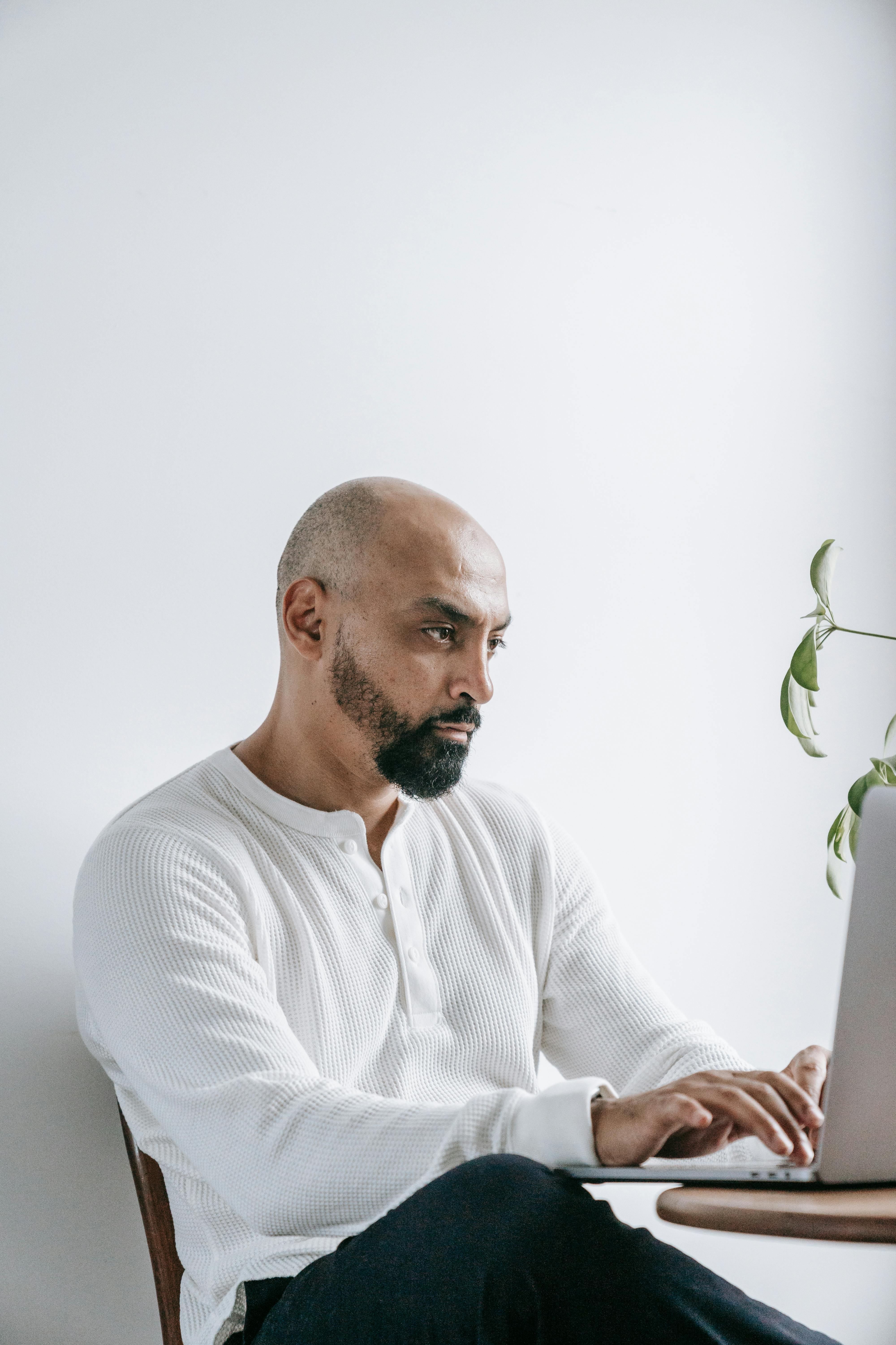 A Man in White Long Sleeves Using Laptop · Free Stock Photo