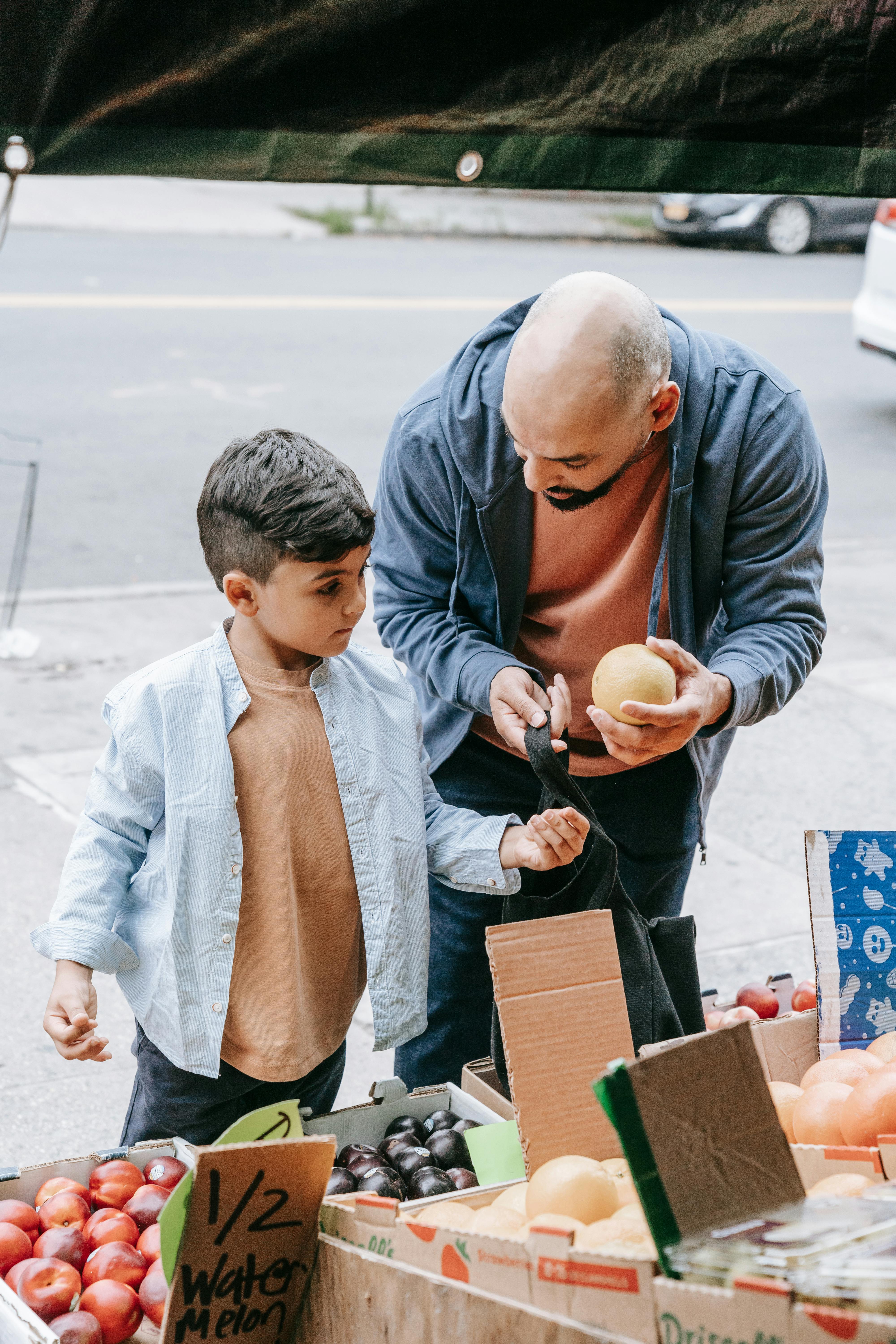 A Man with His Son Shopping in the Market · Free Stock Photo