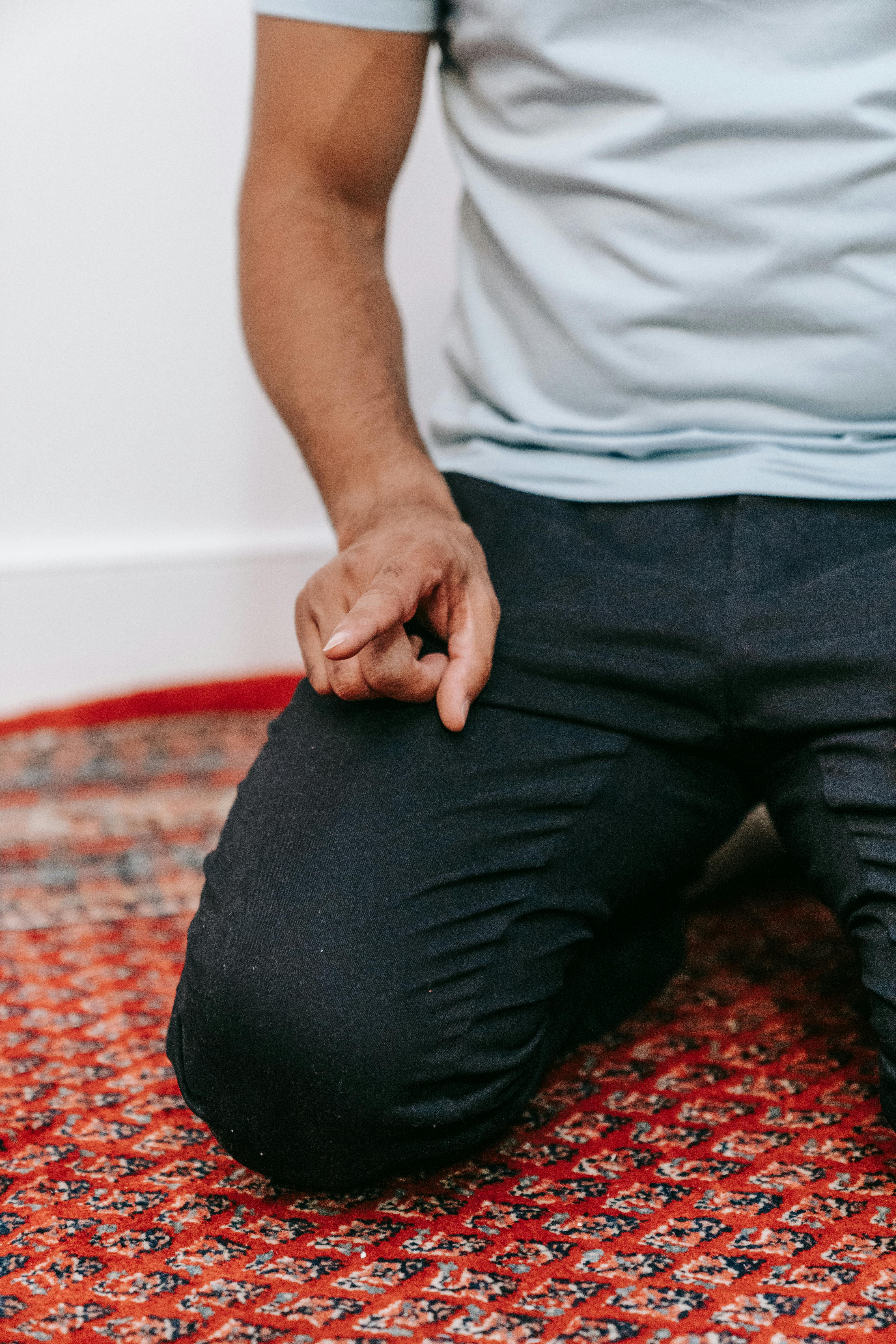 A Man Kneeling on a Rug · Free Stock Photo