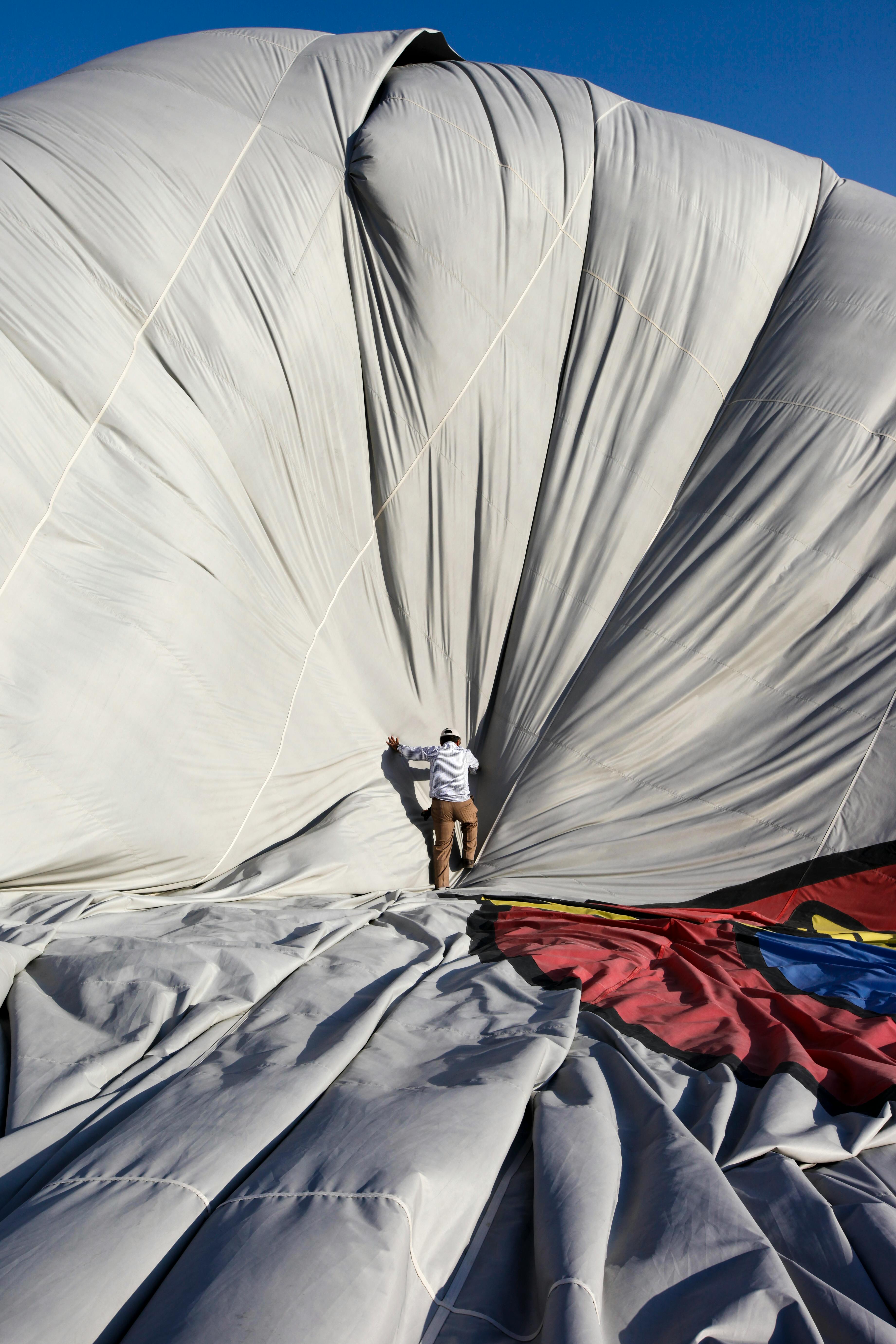 A Man Standing on Gray Hot Air Balloon · Free Stock Photo