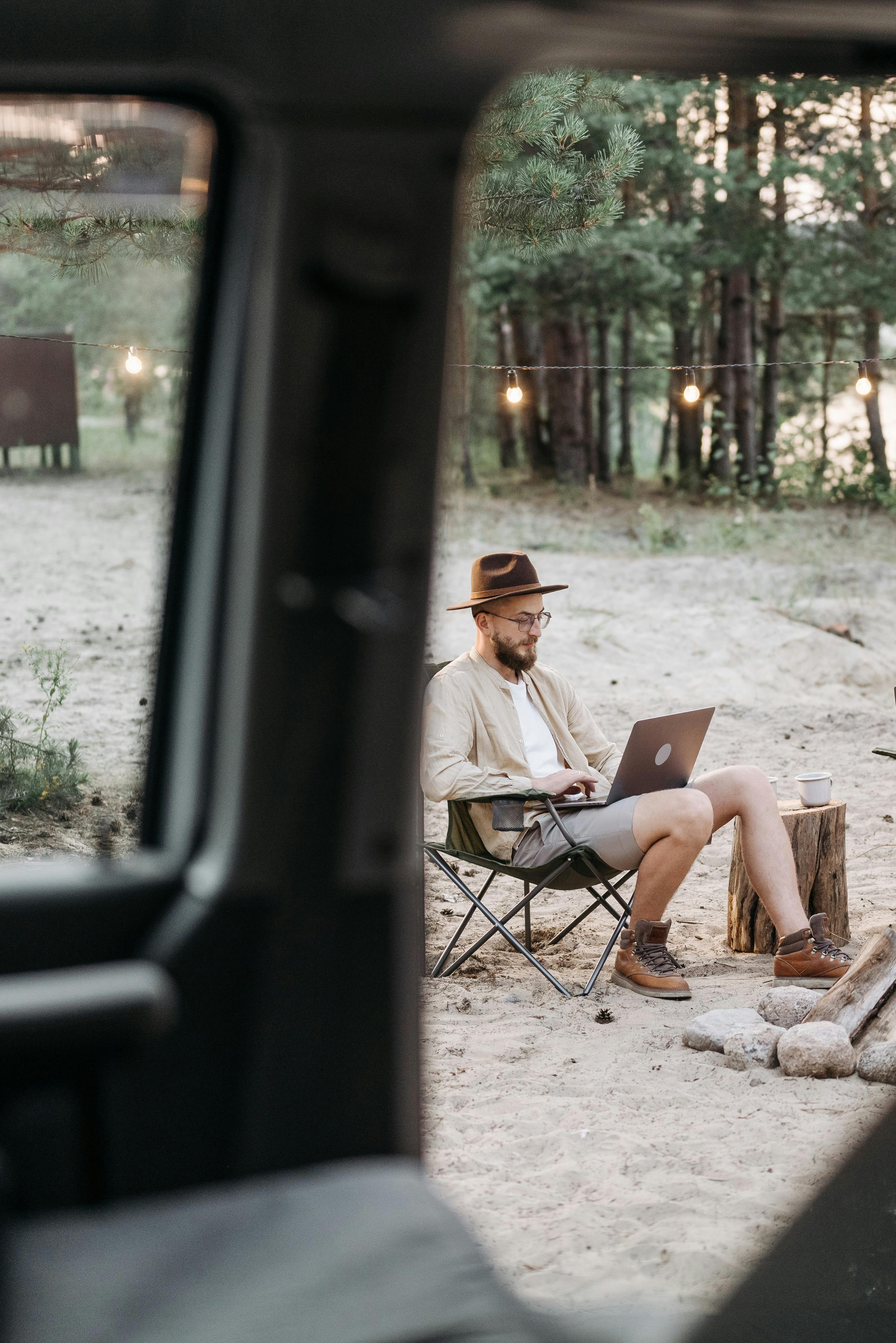 Man Sitting on a Chair Working on a Laptop · Free Stock Photo