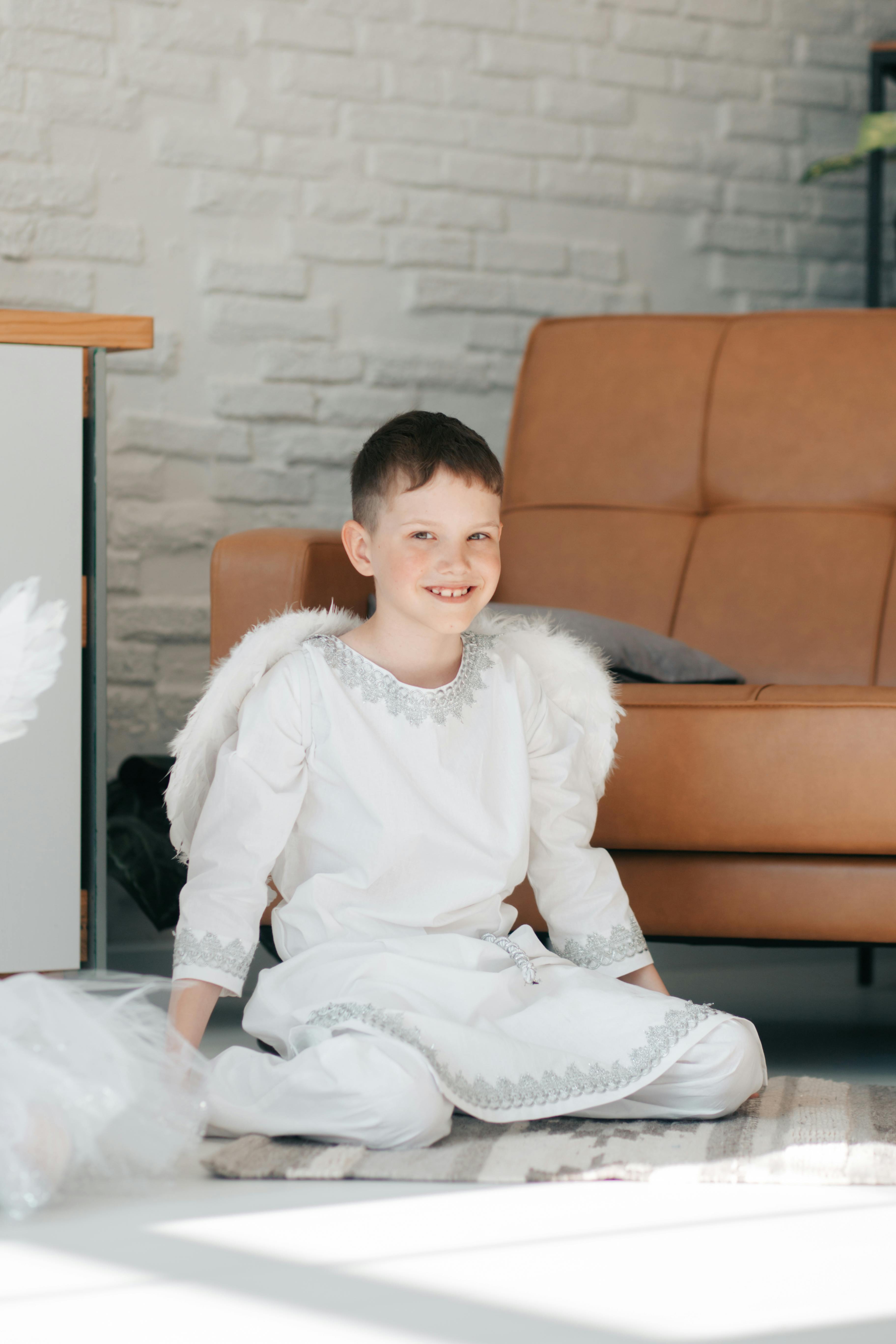 A Boy in Angel Costume Sitting on the Floor · Free Stock Photo