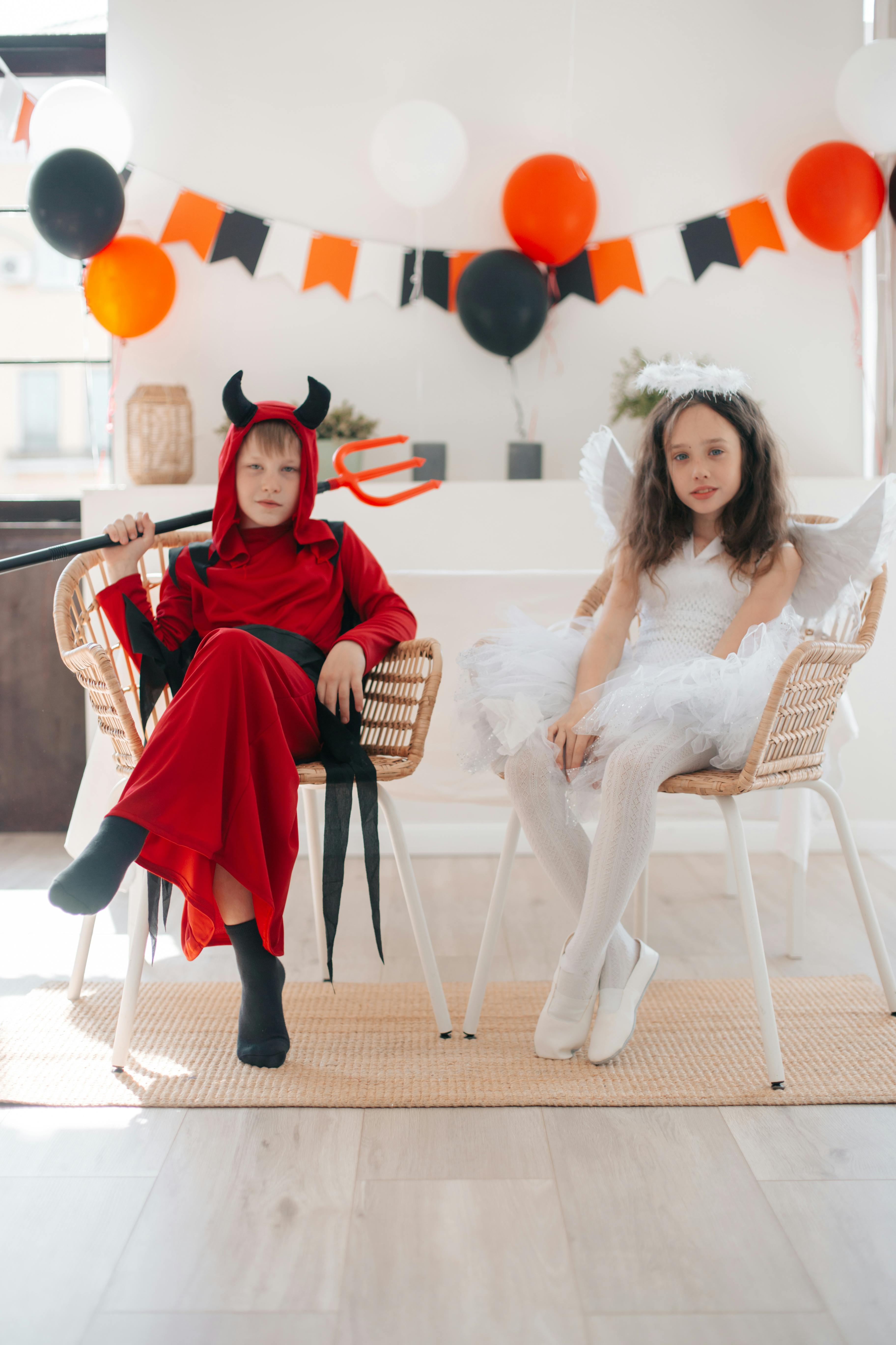 Two Children in Halloween Costumes Sitting on the Chairs · Free Stock Photo