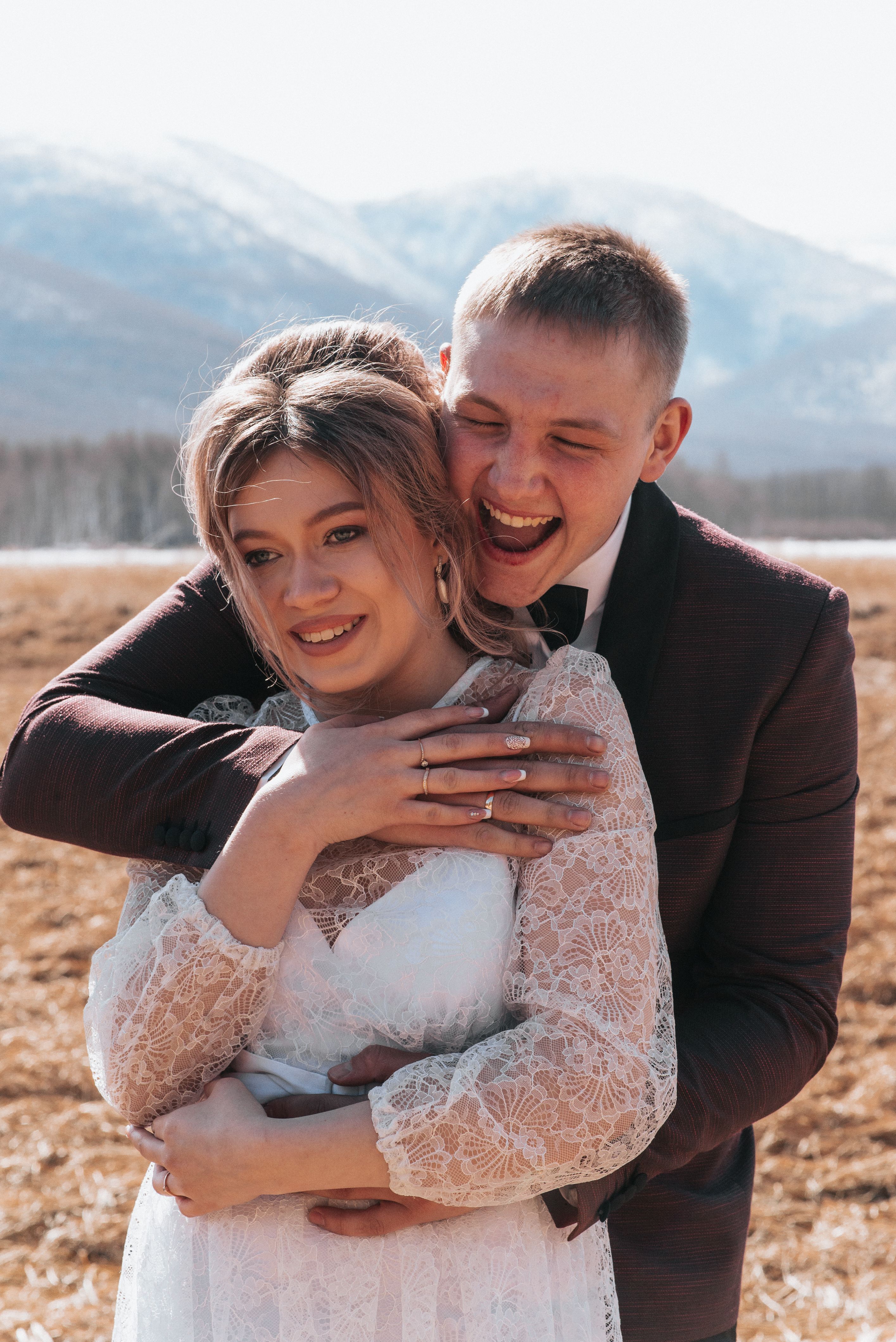 Photo of a Groom Laughing while Hugging Her Bride · Free Stock Photo