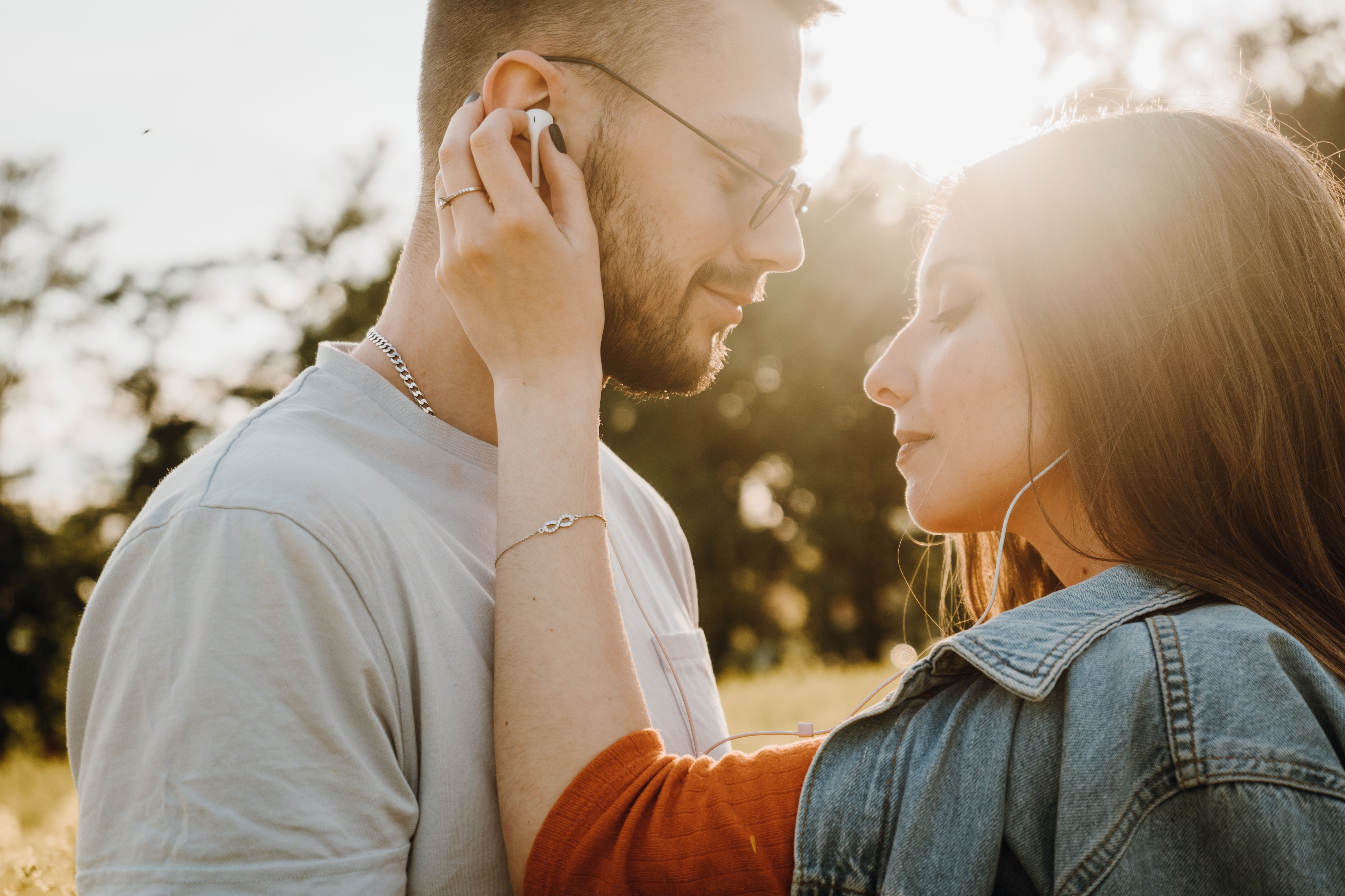 Couple Standing Together with Woman Putting Headphone into Mans Ear ...